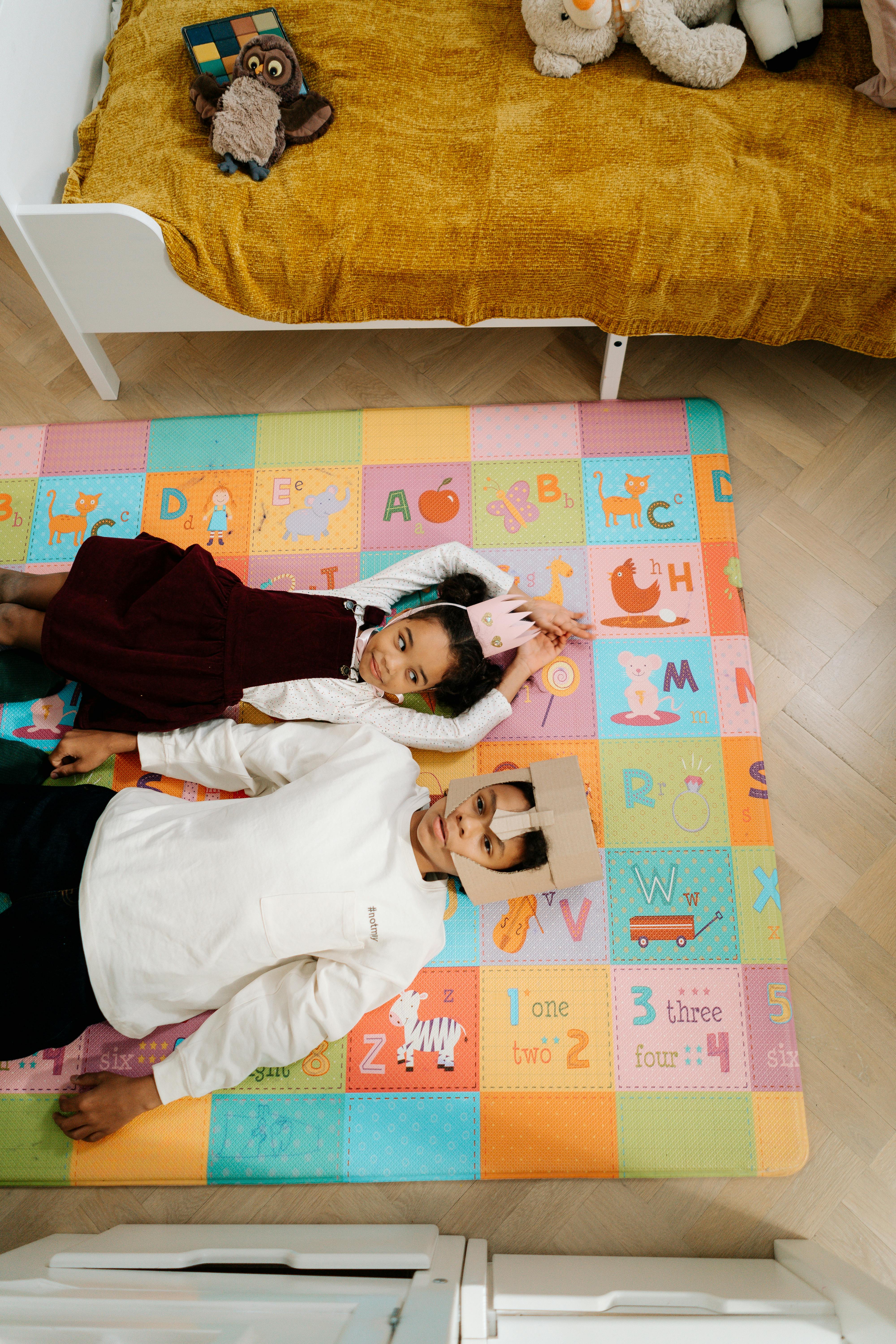 Girl and Boy Lying on a Mat · Free Stock Photo