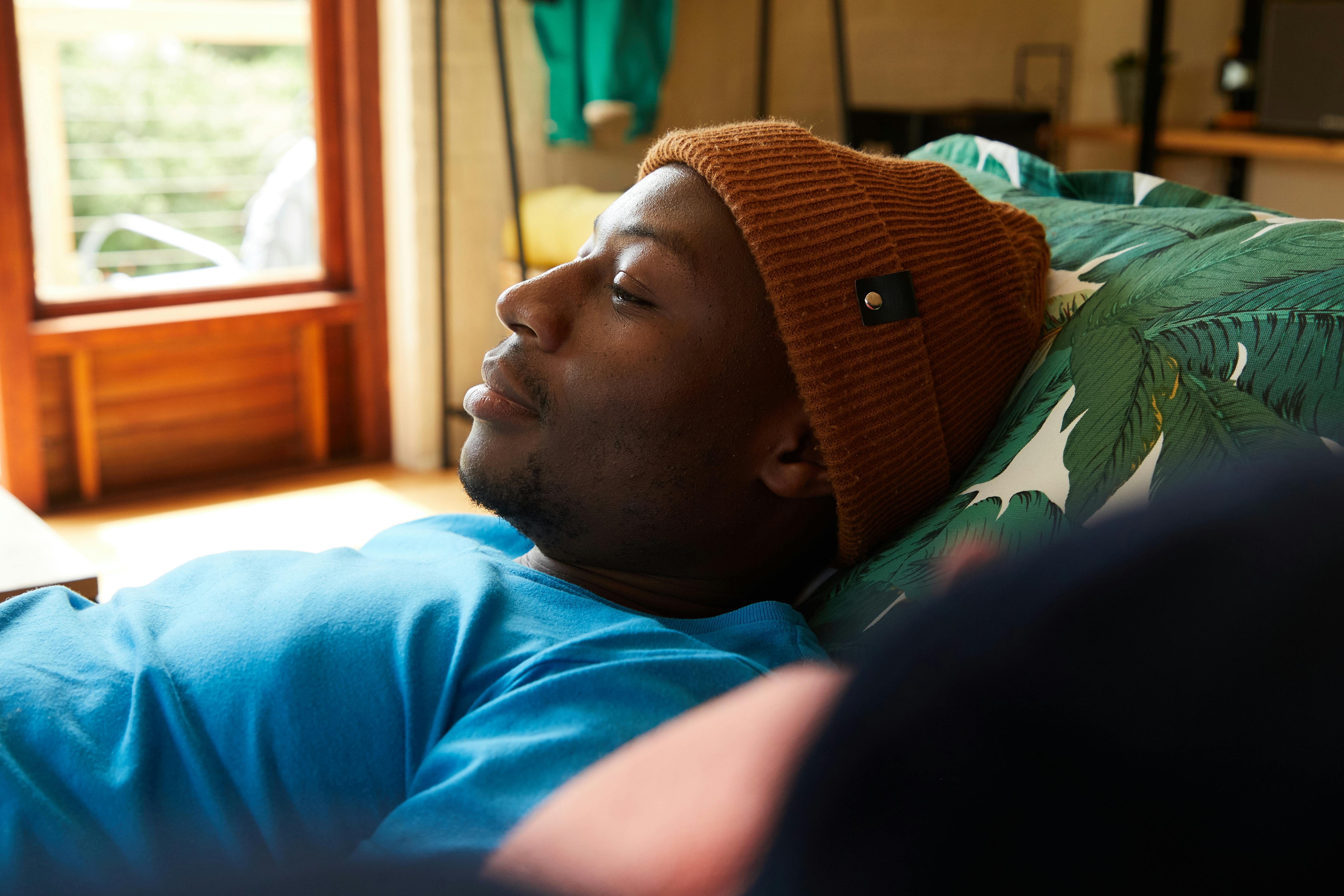 Thoughtful black man relaxing on sofa · Free Stock Photo