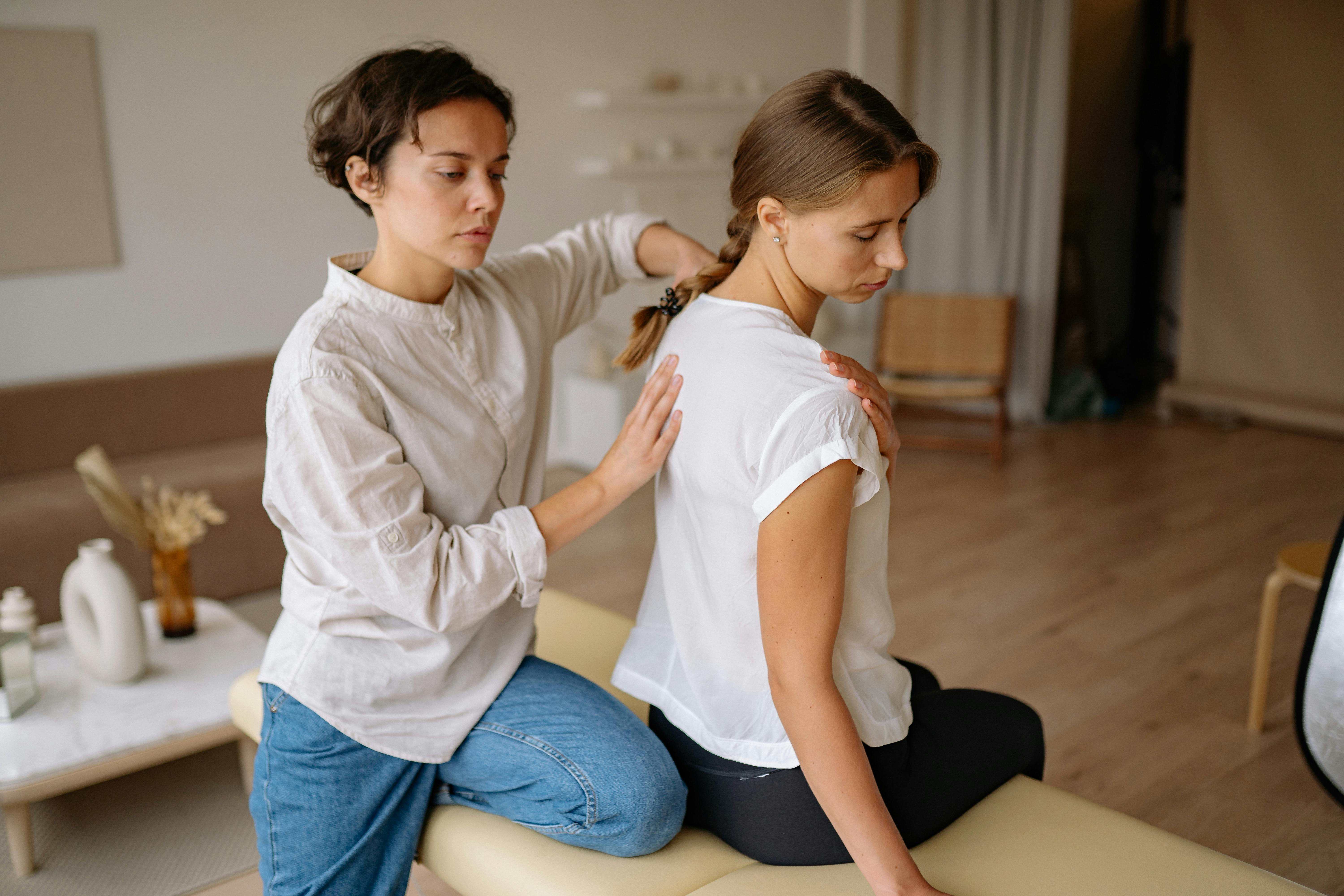 A Client Having a Massage Sitting on a Massage Table · Free Stock Photo