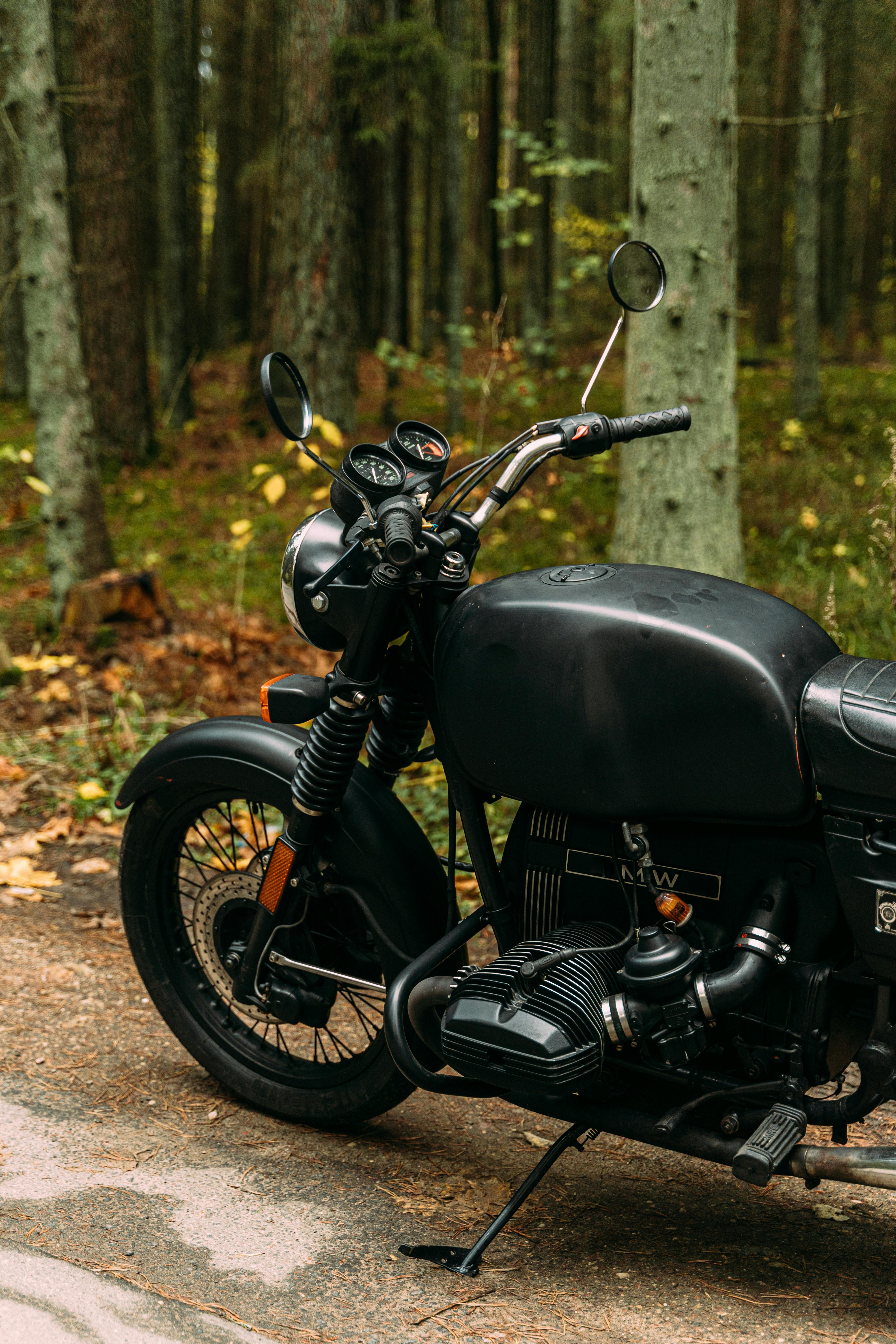 A Black Motorcycle Parked in a Forest · Free Stock Photo