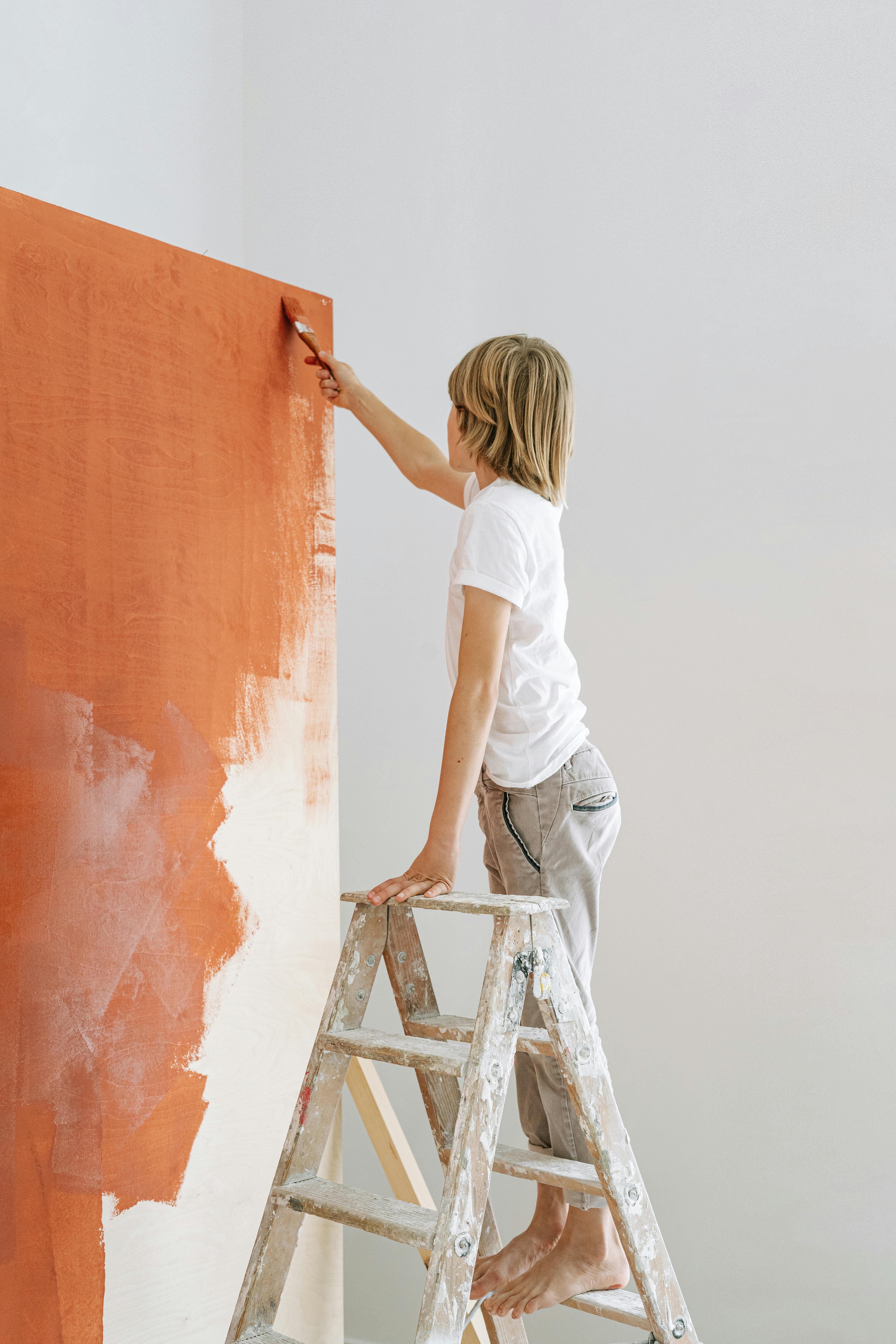 A Person Painting the Wall White · Free Stock Photo