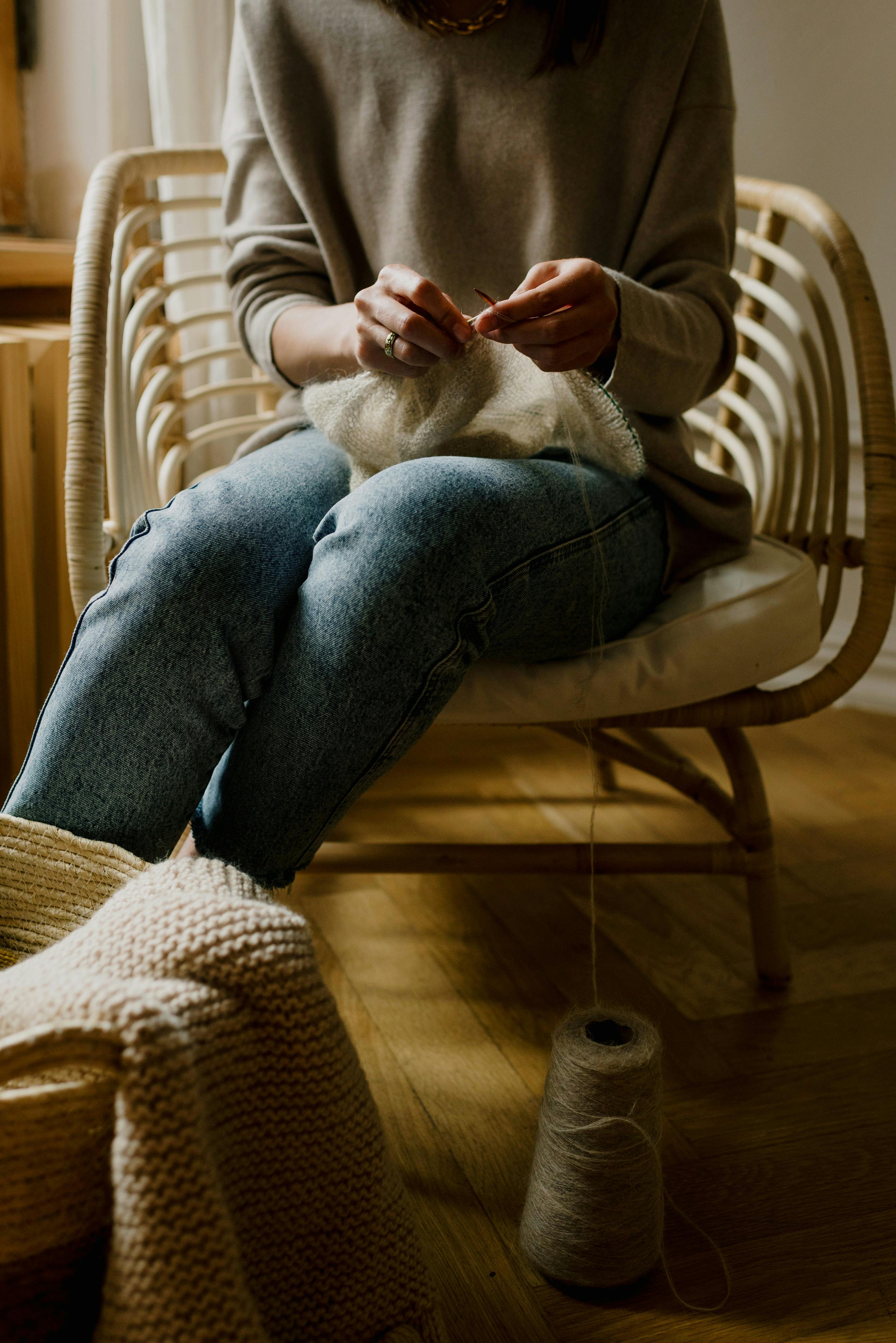 Person sitting on Wooden Chair Knitting a Crochet · Free Stock Photo