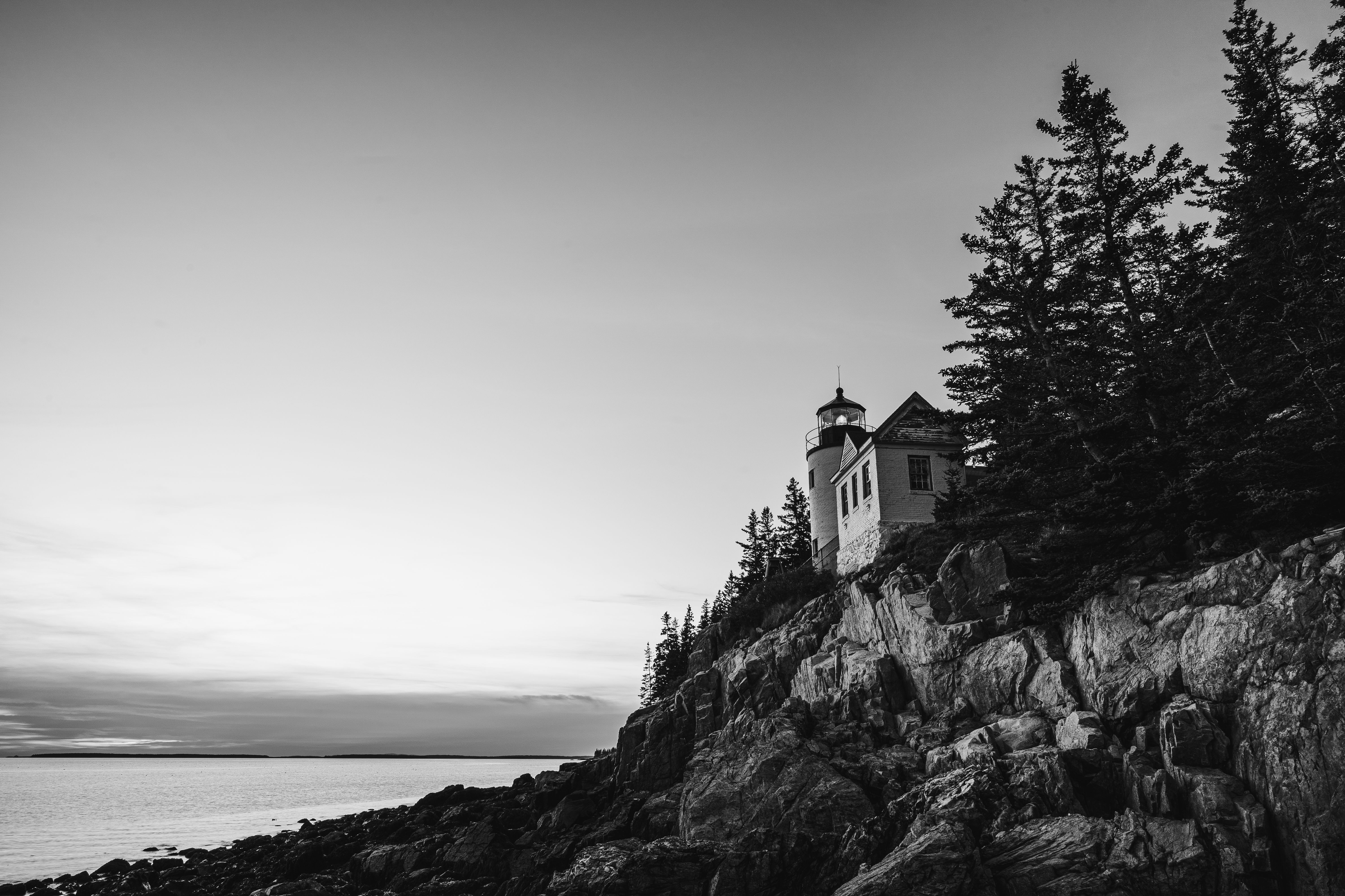 Grayscale Photo of Building on Cliff Near Body of Water · Free Stock Photo