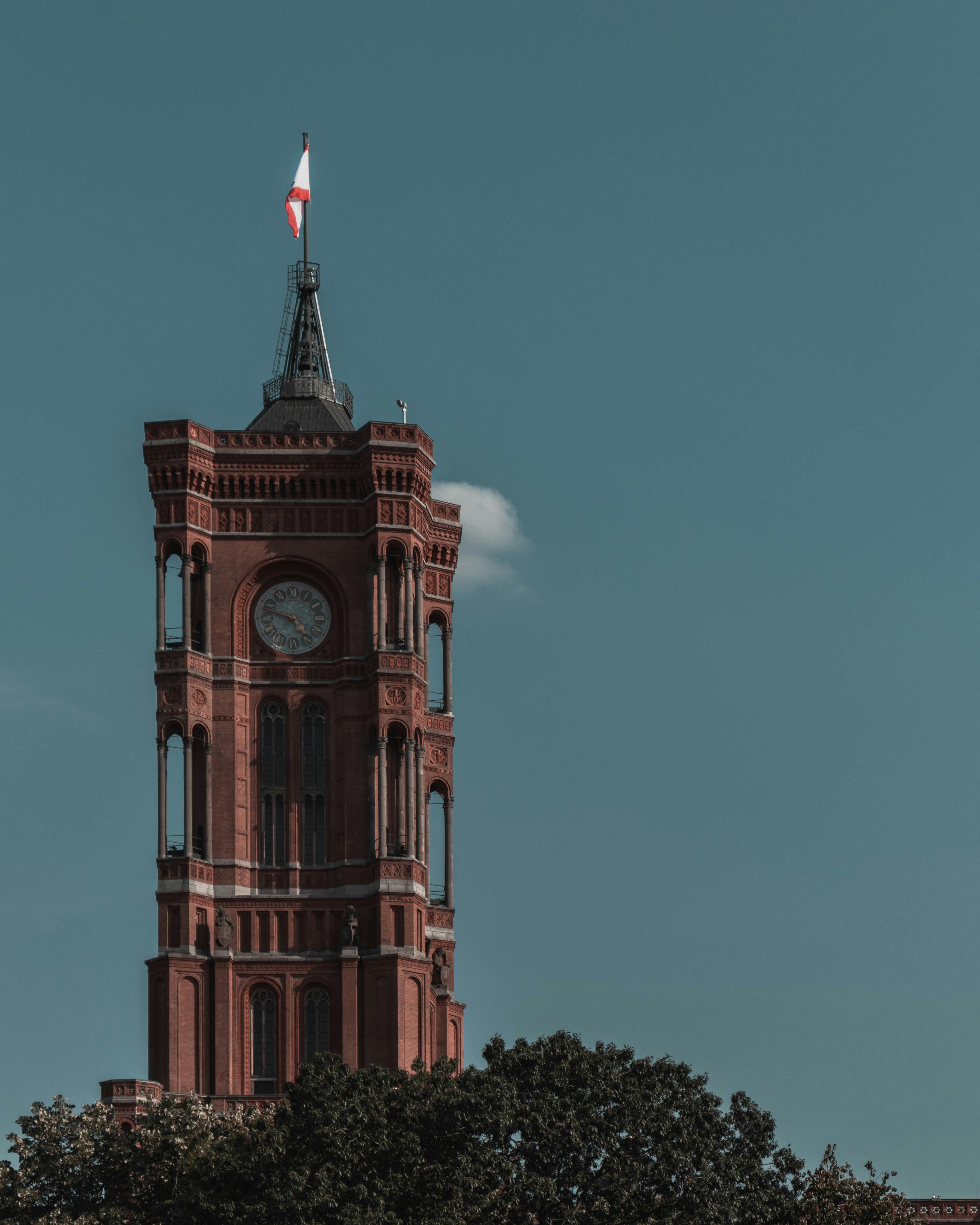 Brown Concrete Clock Tower Under Blue Sky · Free Stock Photo