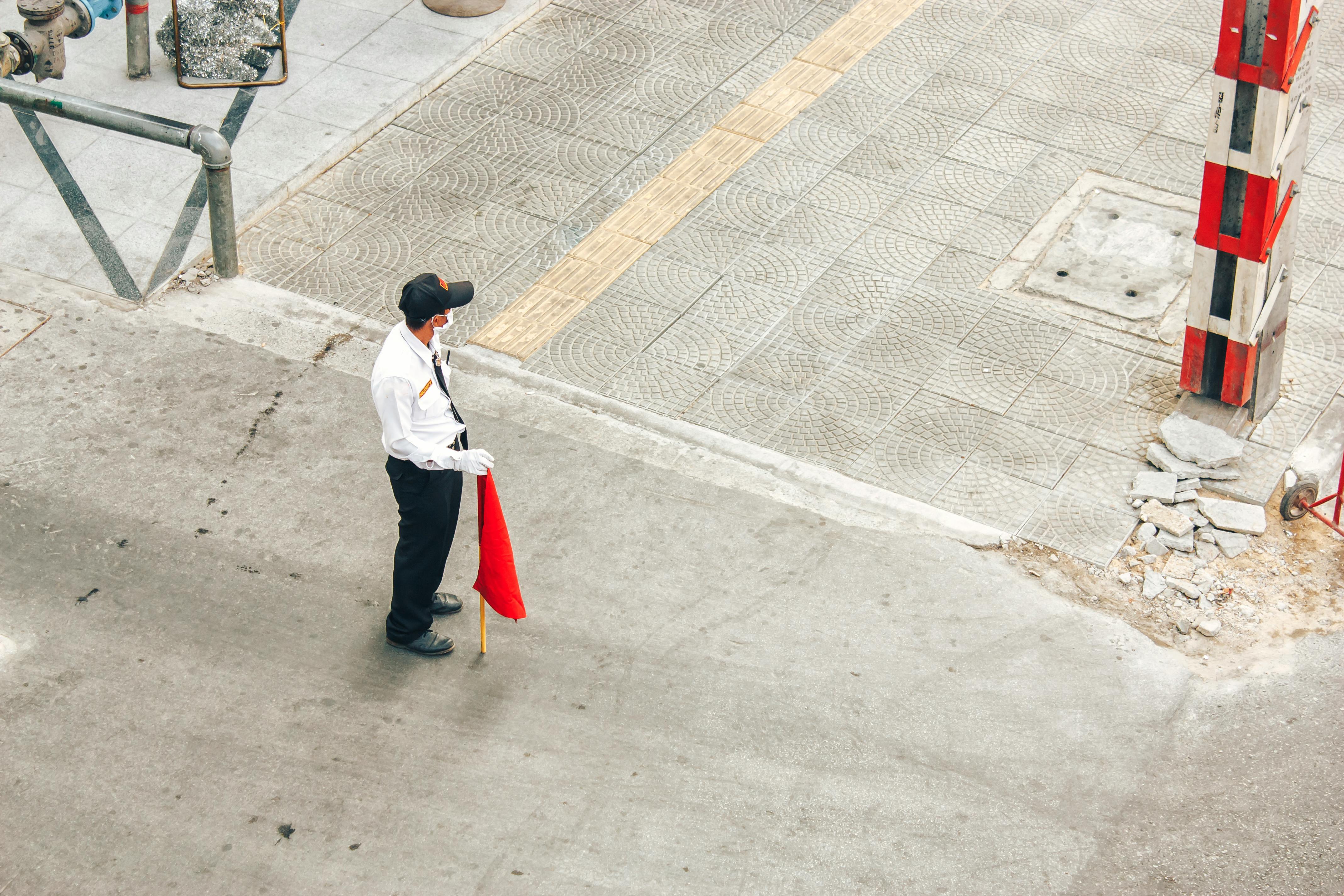Man with Red Flag Standing in Empty Street · Free Stock Photo