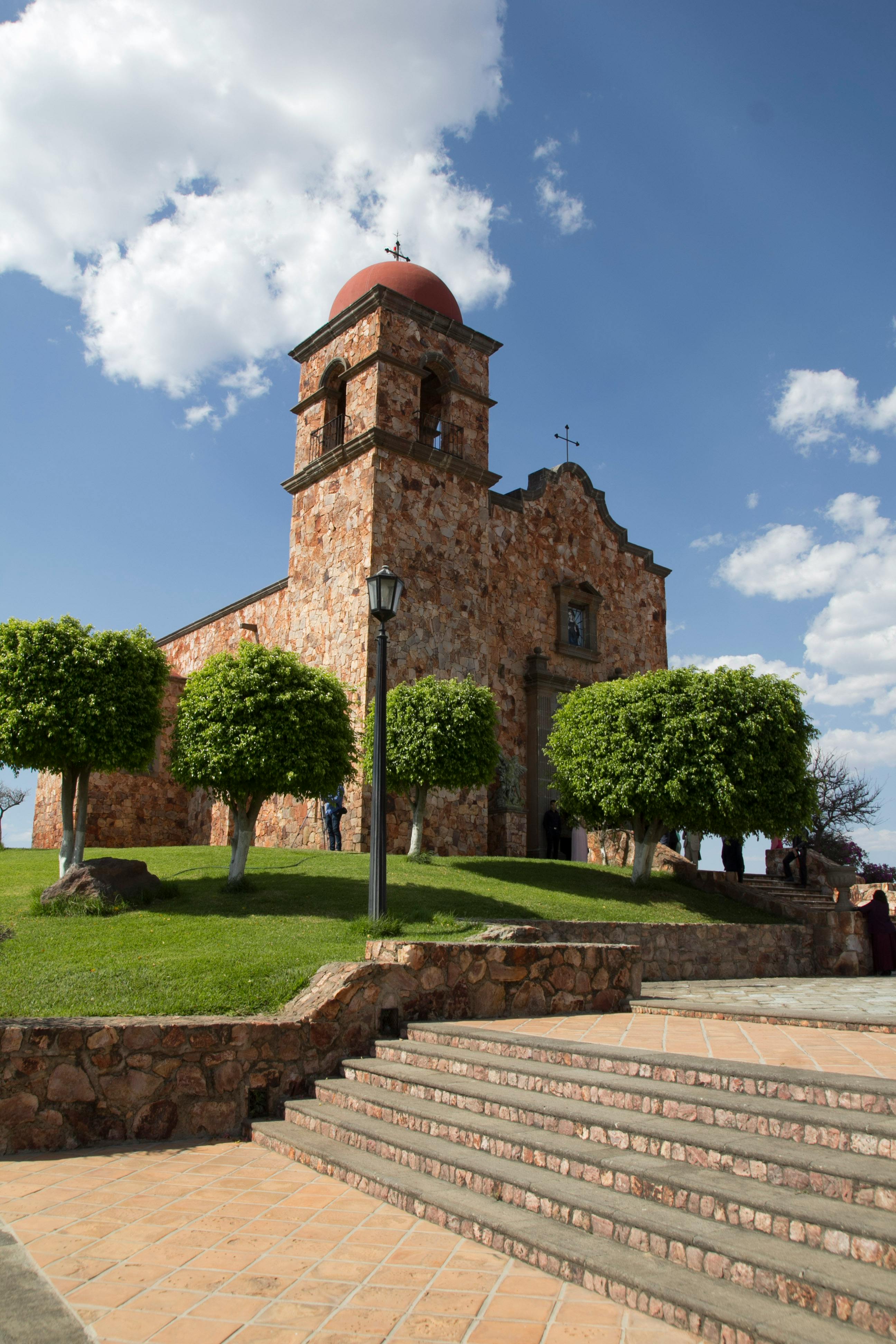 Brown Church with Brick Wall Under the White Clouds · Free Stock Photo