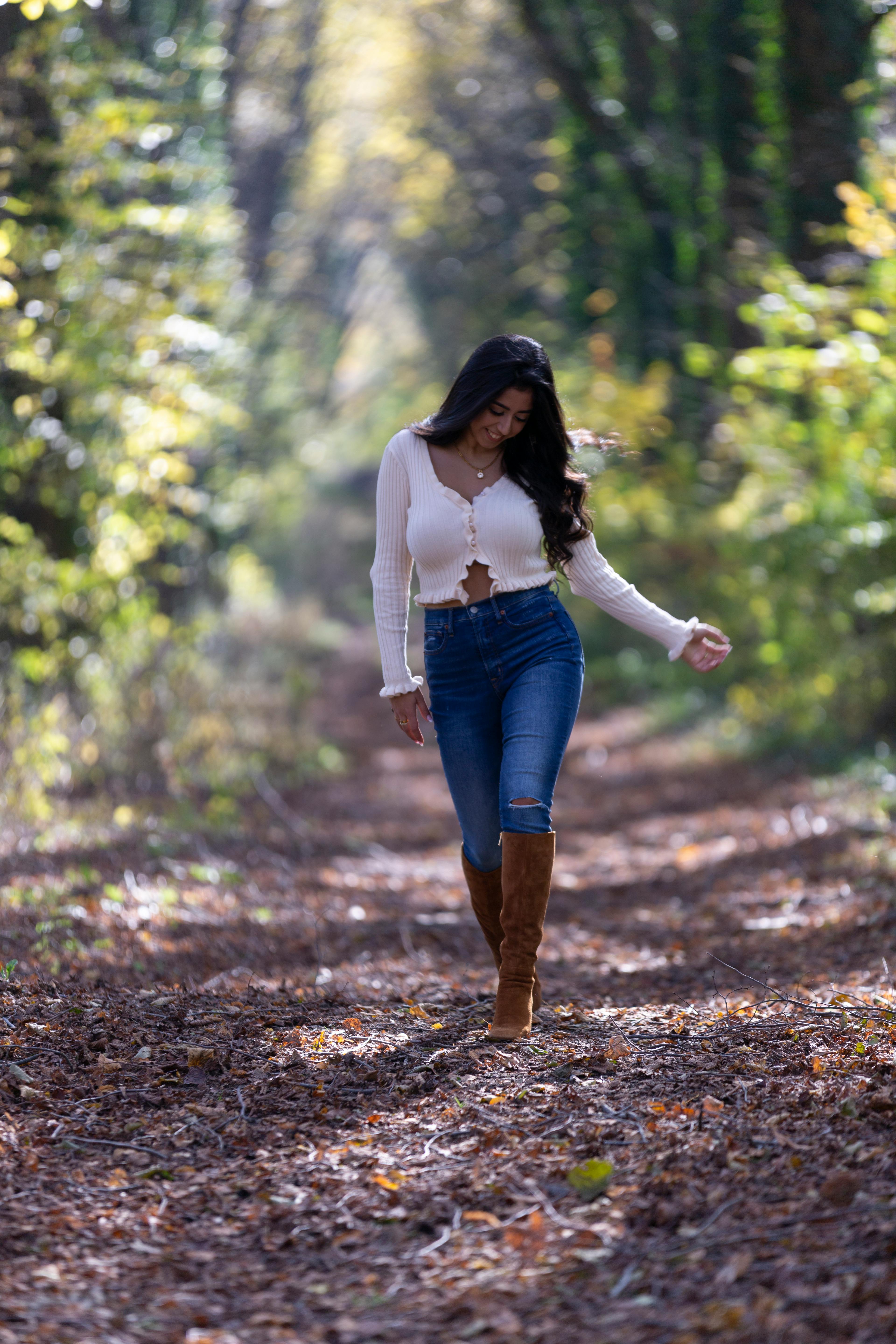 Attractive woman with basket walking on footpath between lush trees ...