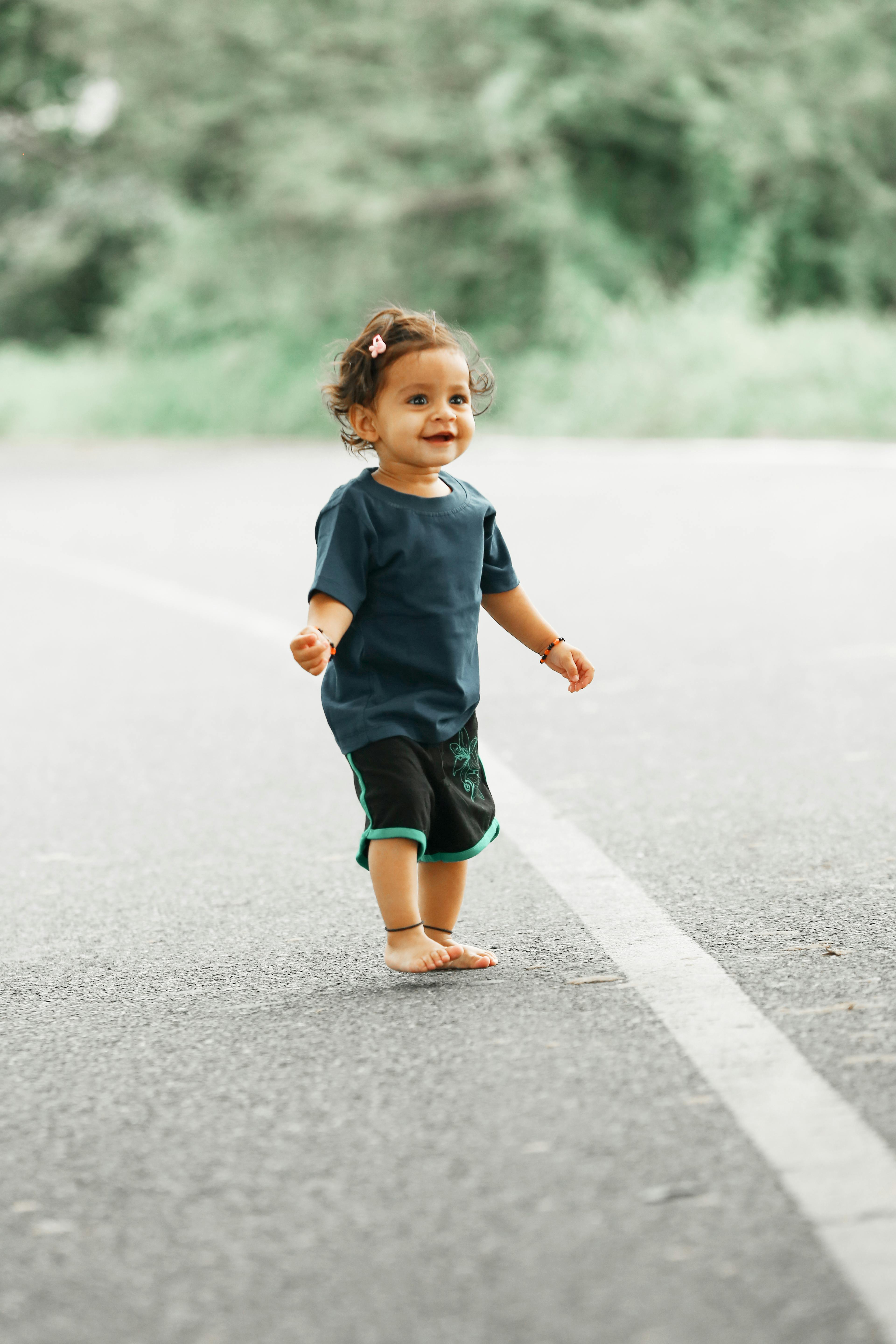 Girl Standing on Asphalt Road · Free Stock Photo