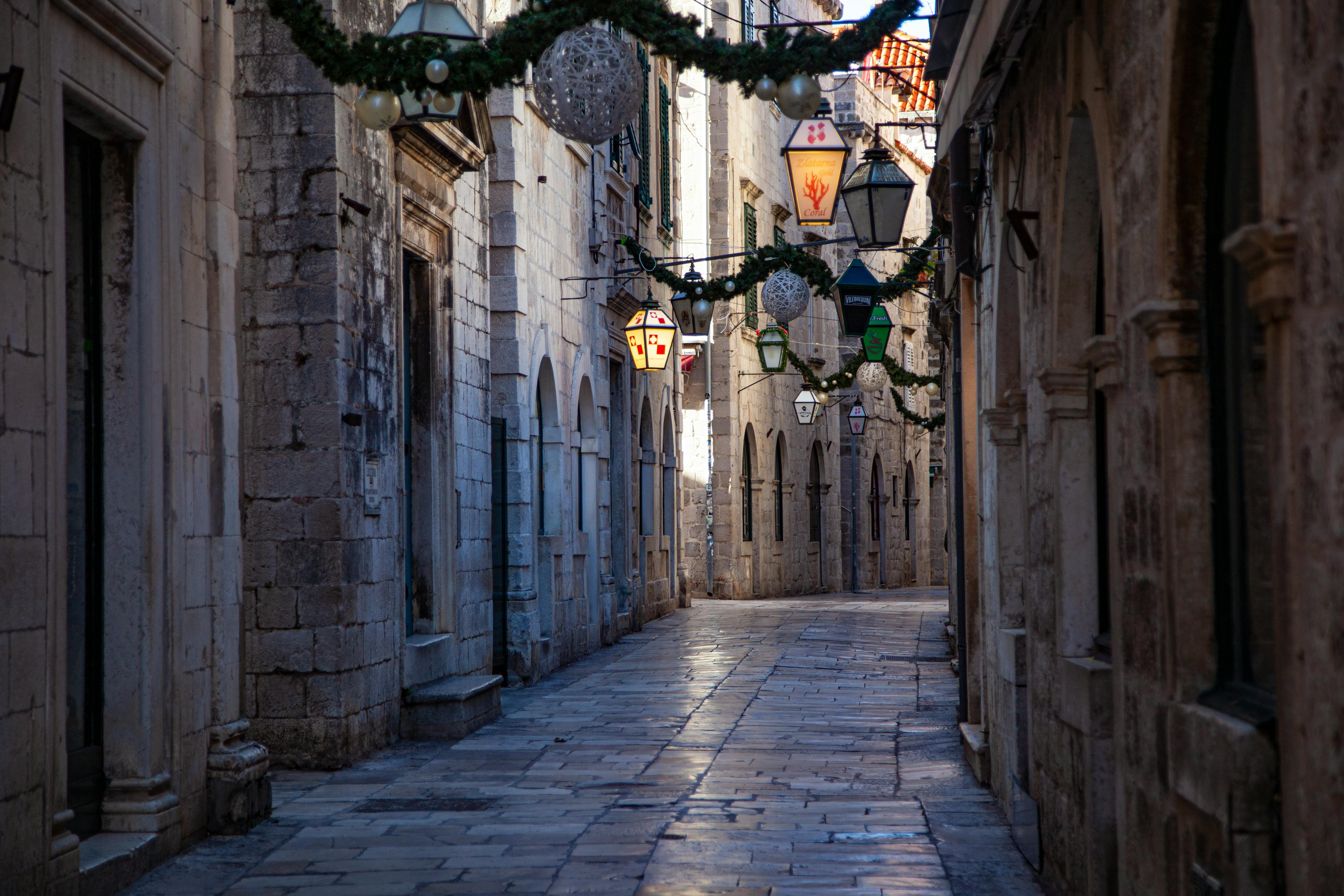 Aged cobblestone town street with pedestrians · Free Stock Photo