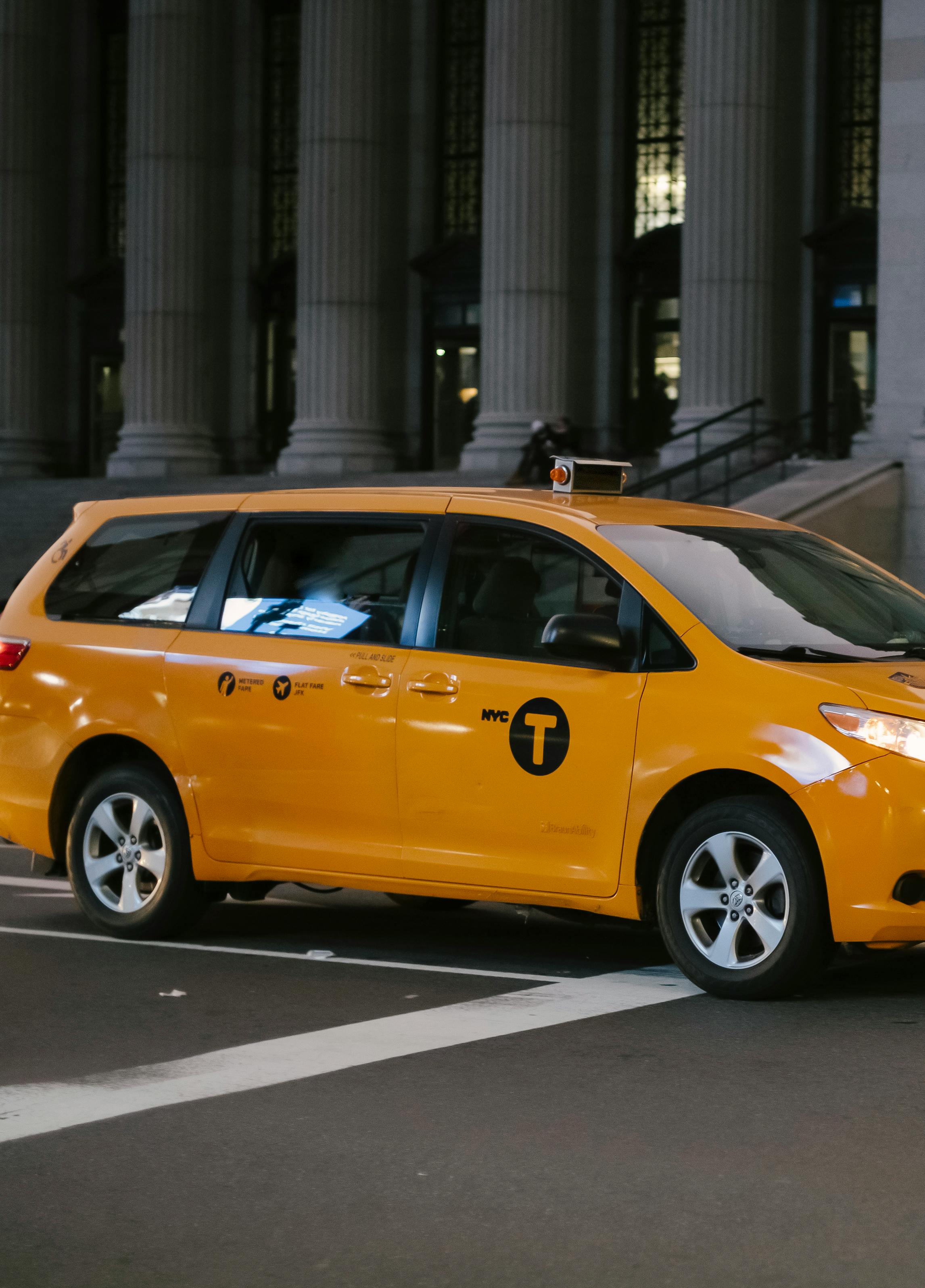 Contemporary minivan cab on street near building with pillars · Free ...