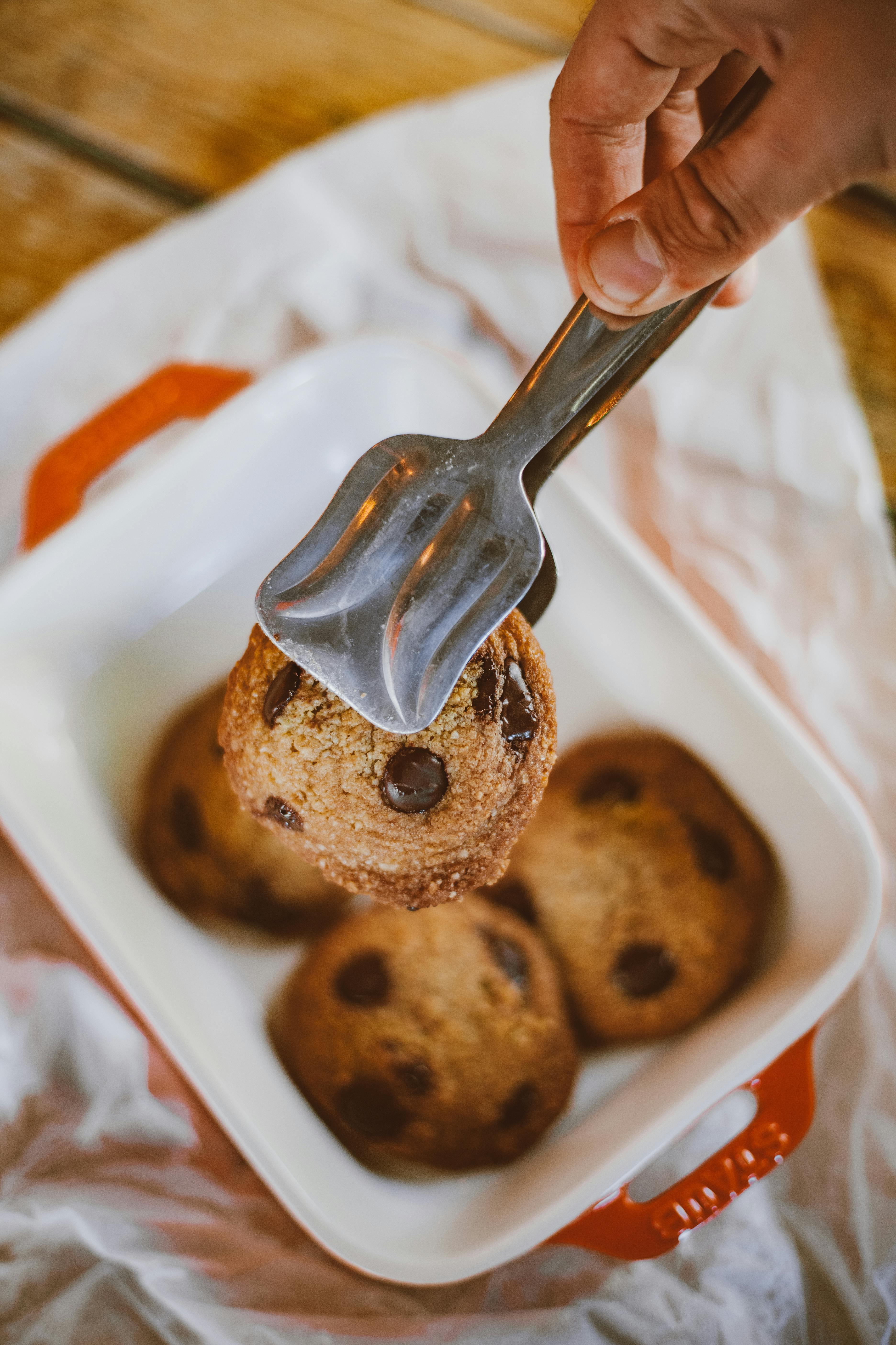 Picking Cookies with a Tong · Free Stock Photo
