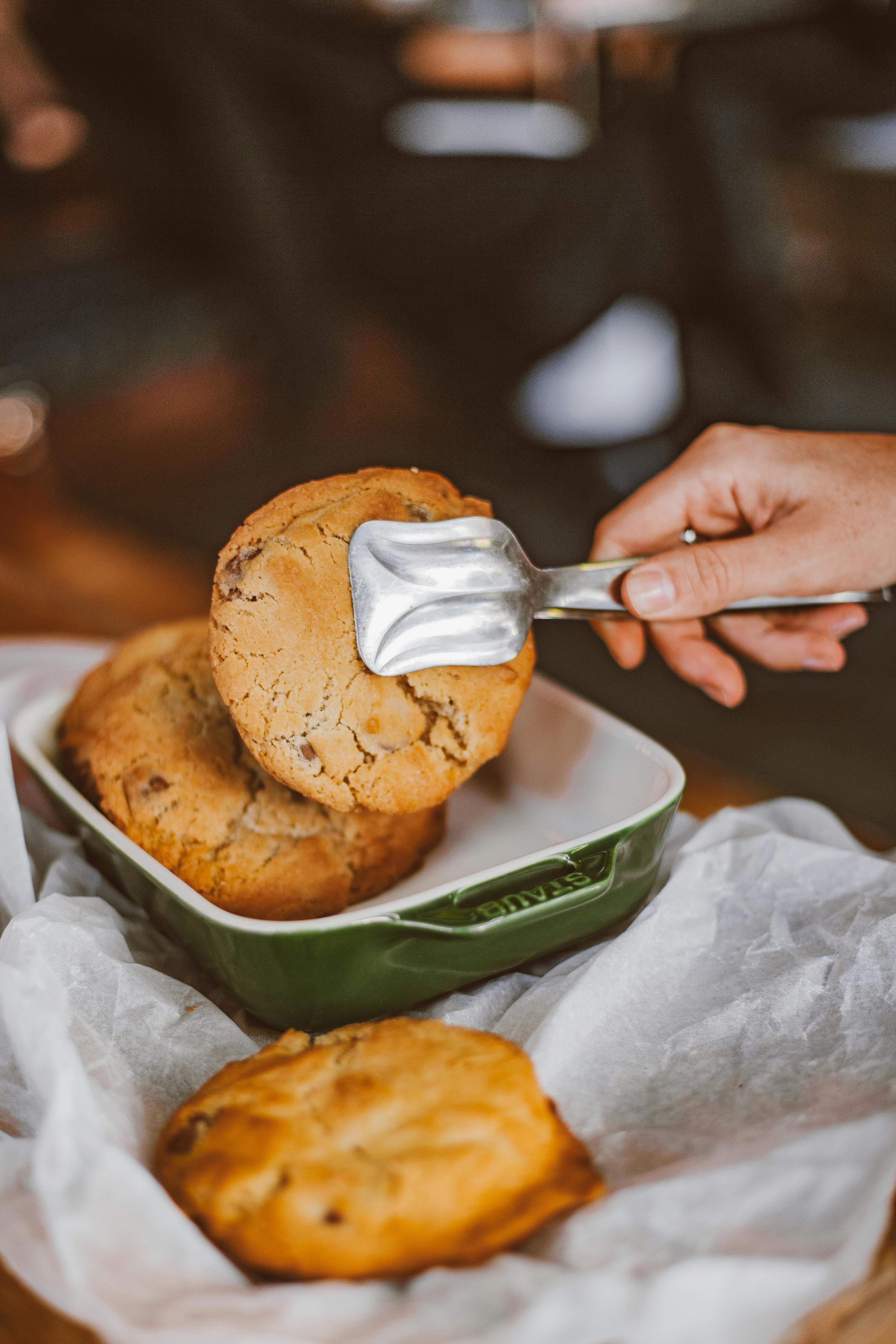 A Person Transferring Cookies on a Food Tray with a Tong · Free Stock Photo