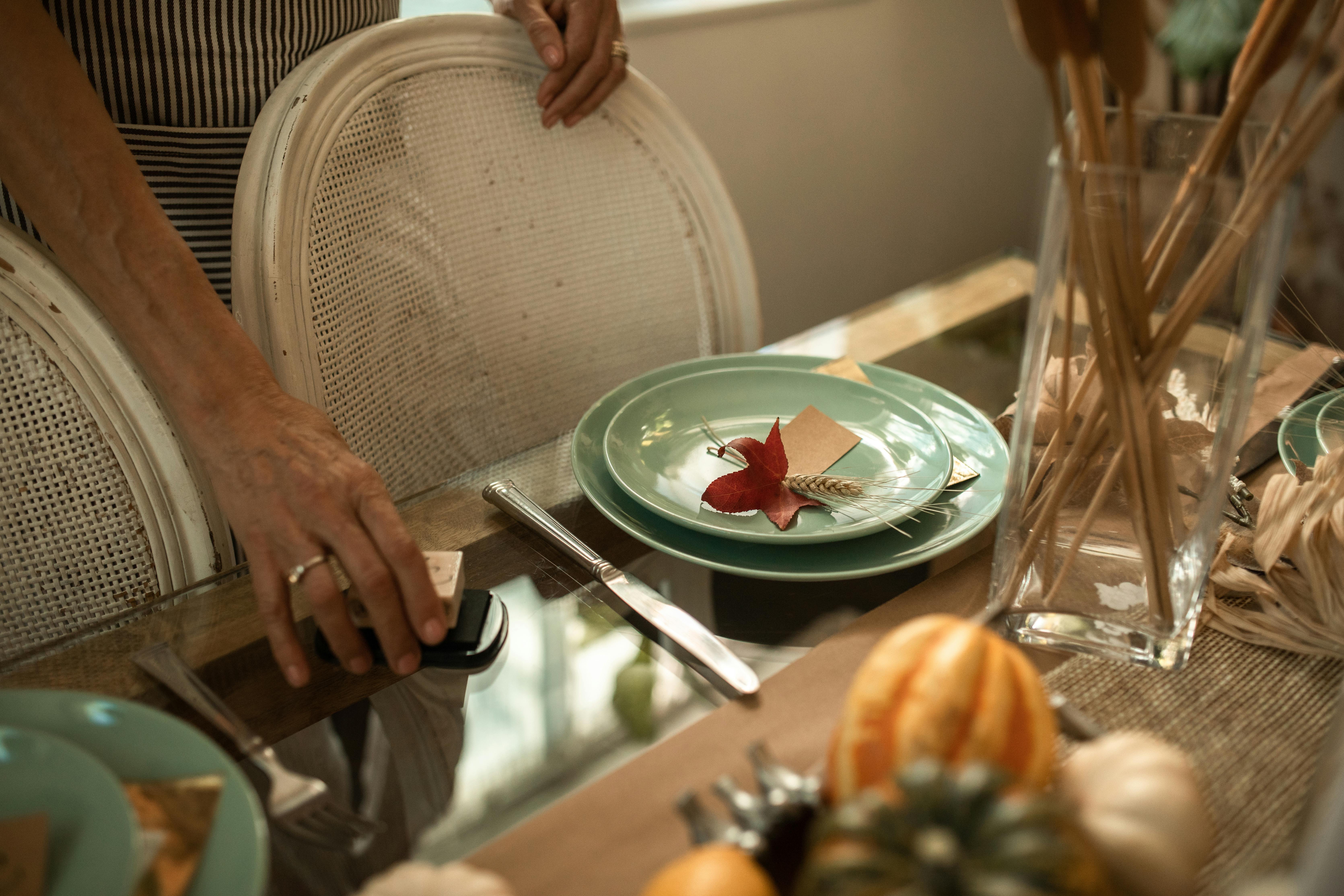Plates Set on Table with Person Standing Behind · Free Stock Photo