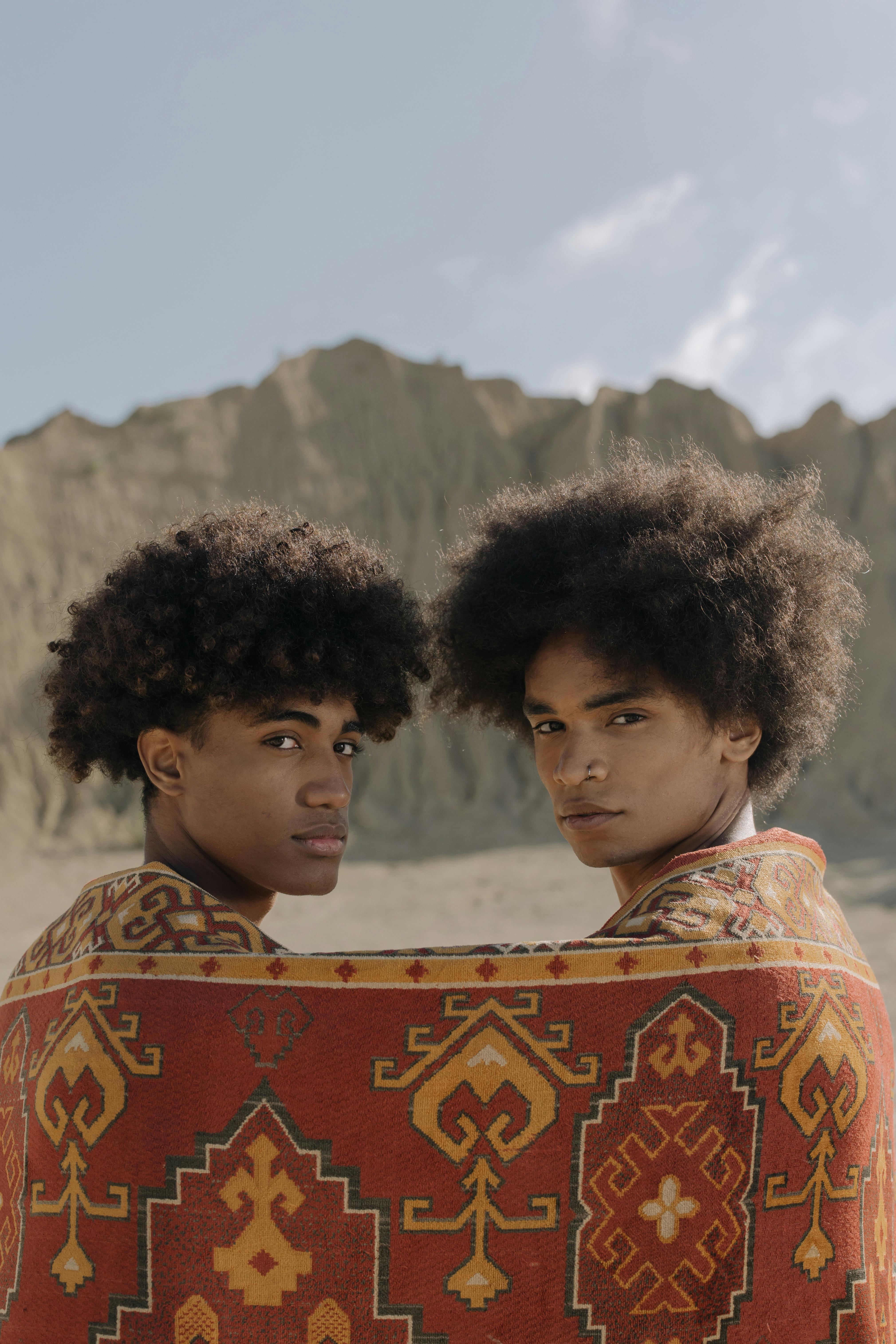 Two Men Wrapped in a Printed Blanket · Free Stock Photo