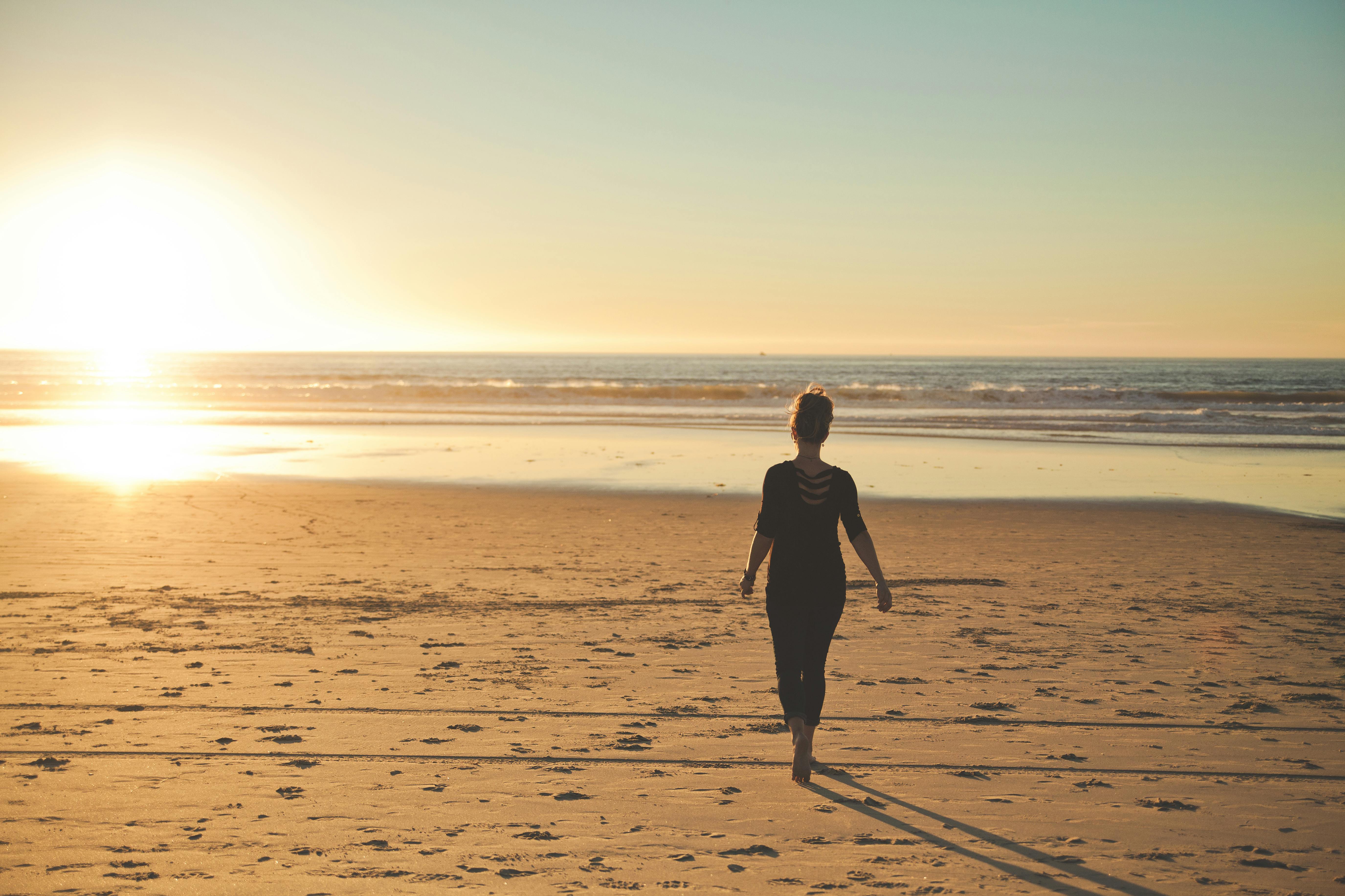 Person Walking on Beachshore · Free Stock Photo