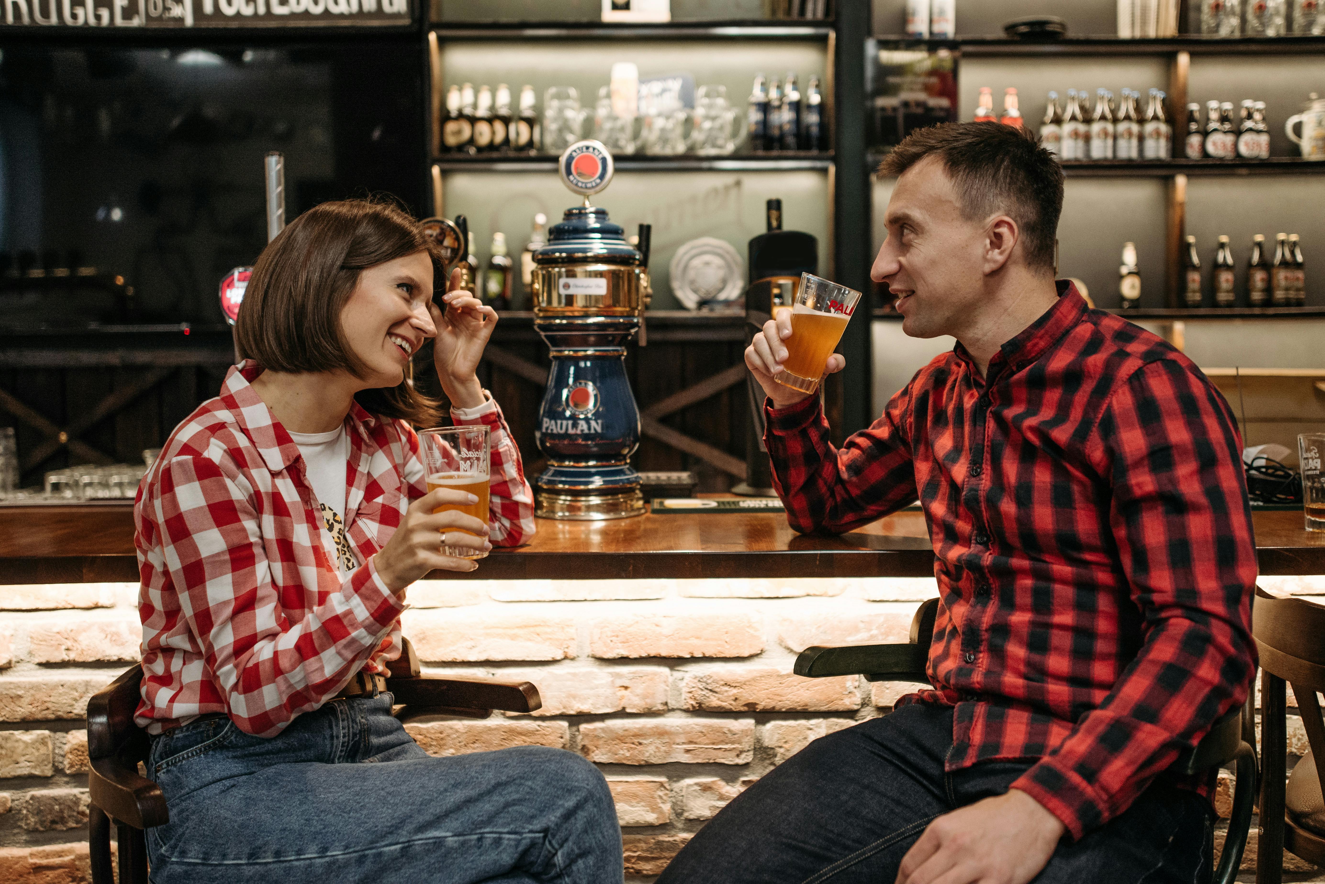 Man and Woman Sitting on Chairs at the Bar · Free Stock Photo