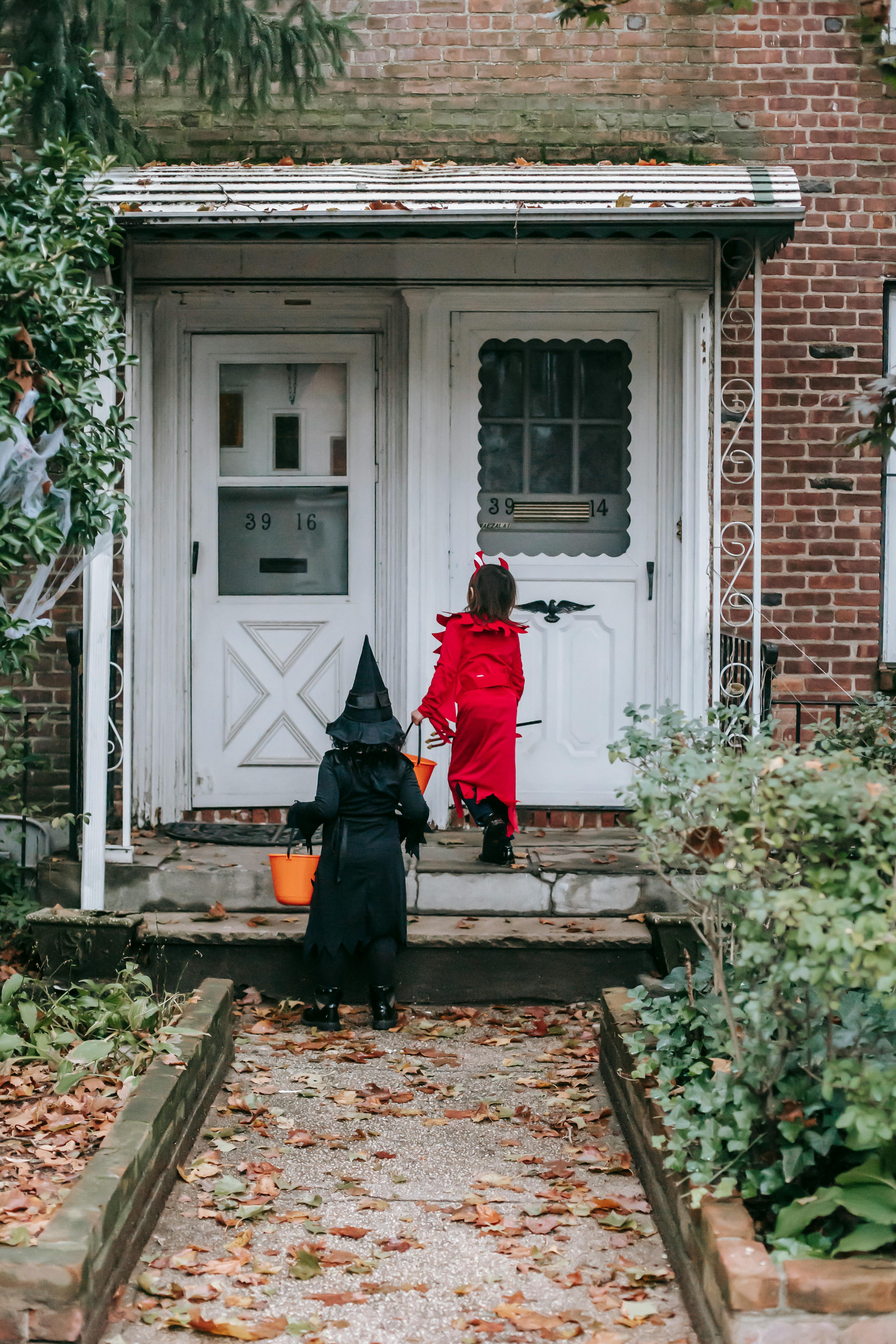 Unrecognizable kids in Halloween costumes walking to house · Free Stock ...