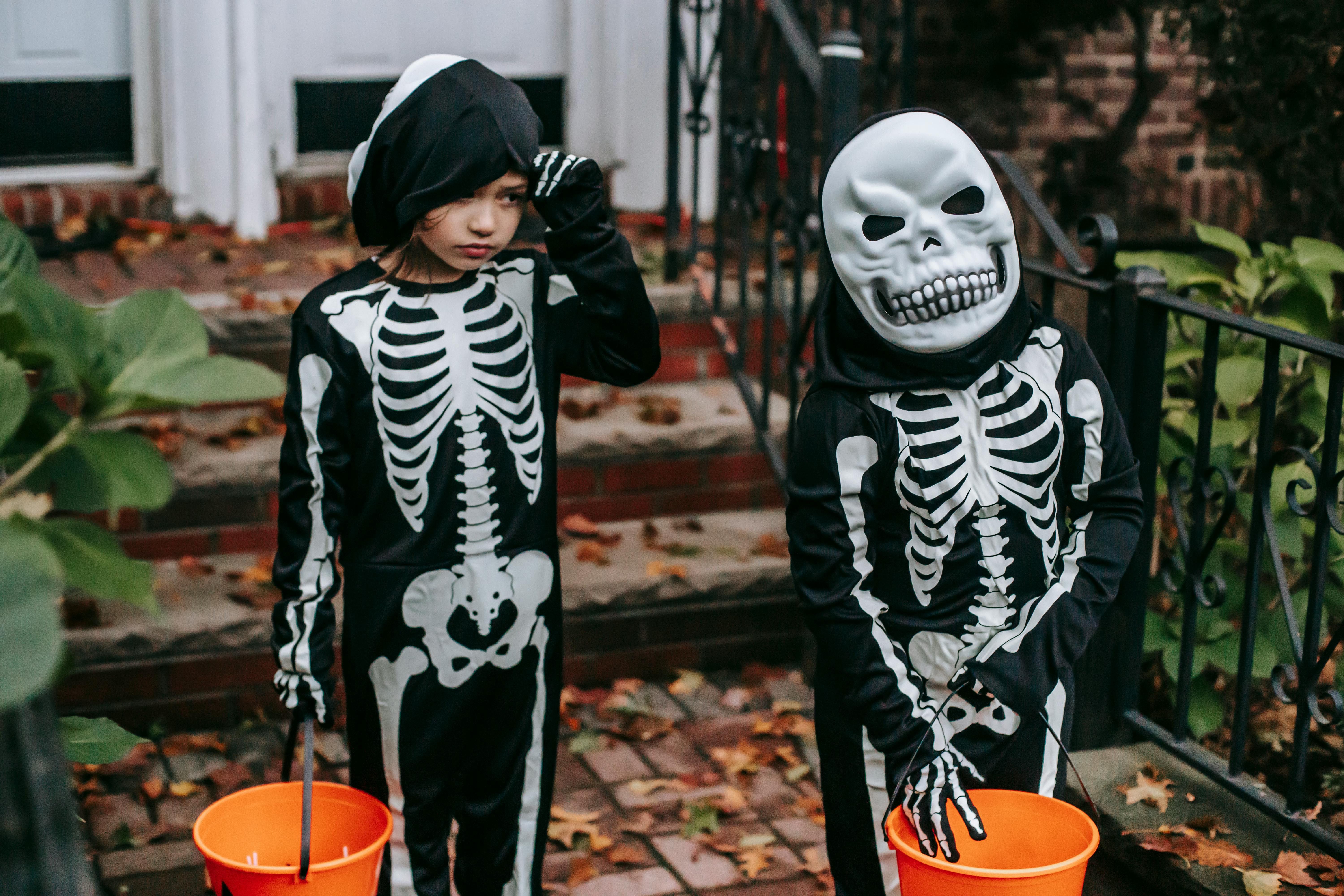 Children in skeleton costumes trick or treating in Halloween · Free ...
