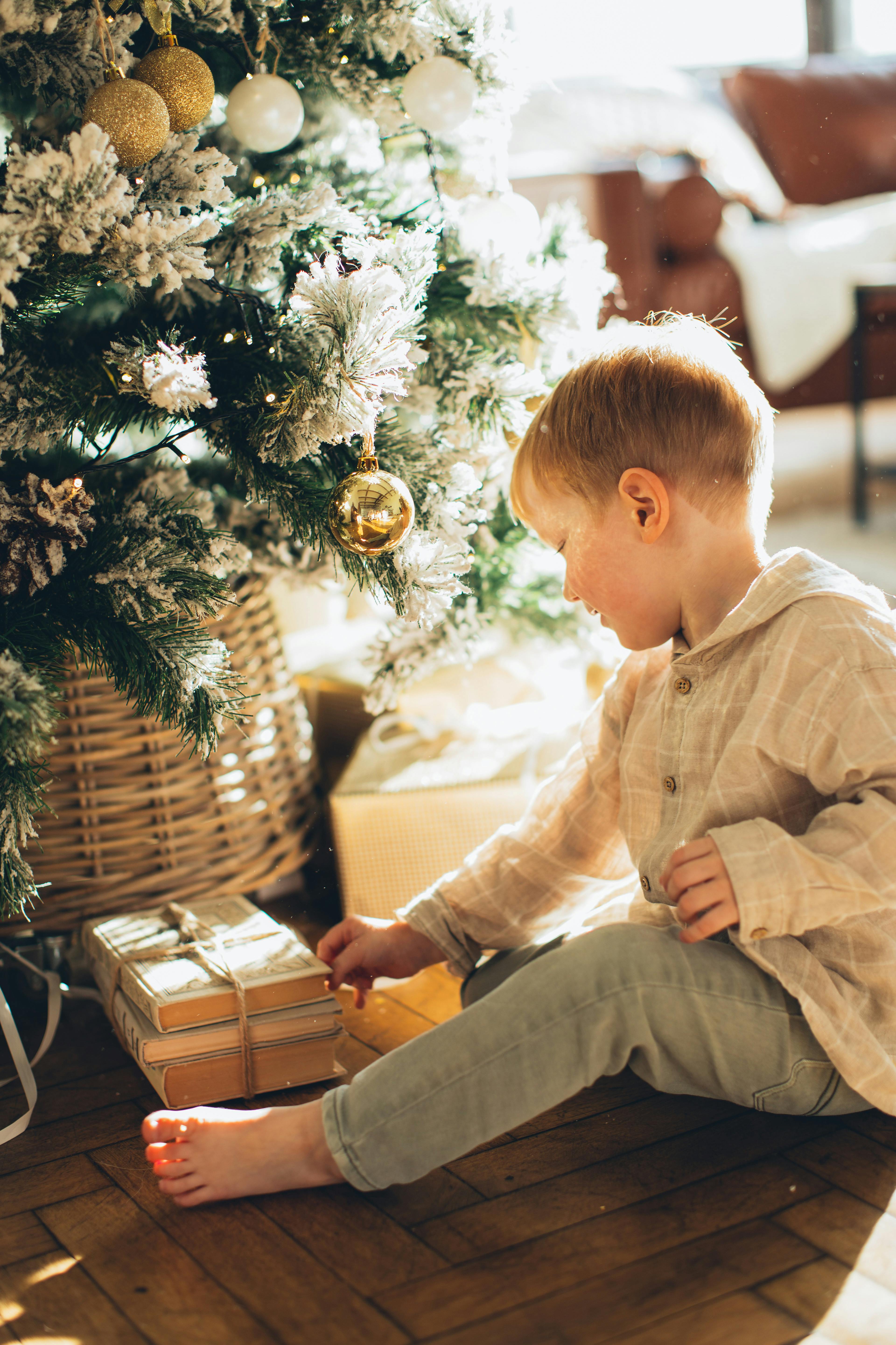 Boy Playing Under a Christmas Tree · Free Stock Photo