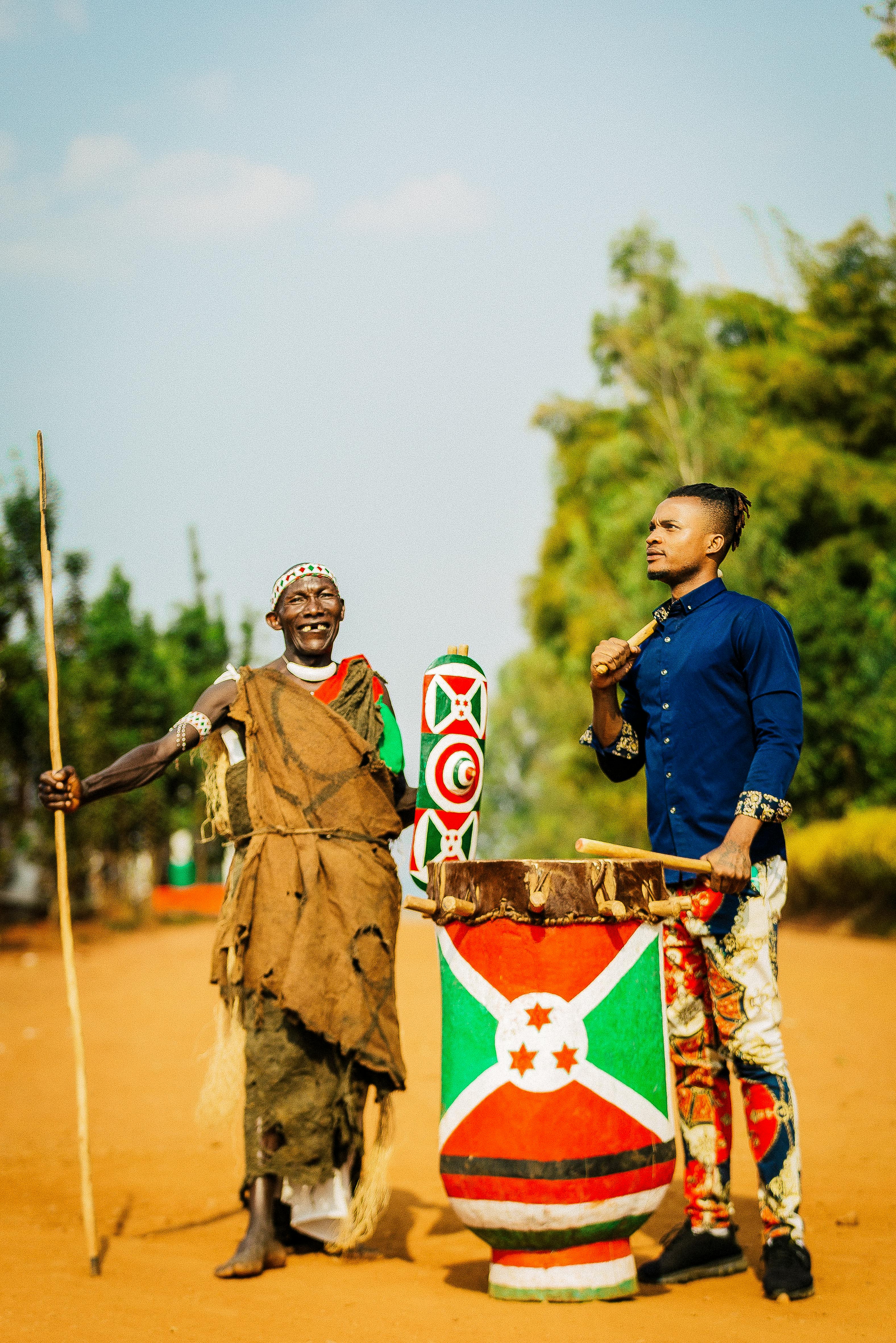 Two Men Standing Beside a Traditional Burundi Drum · Free Stock Photo