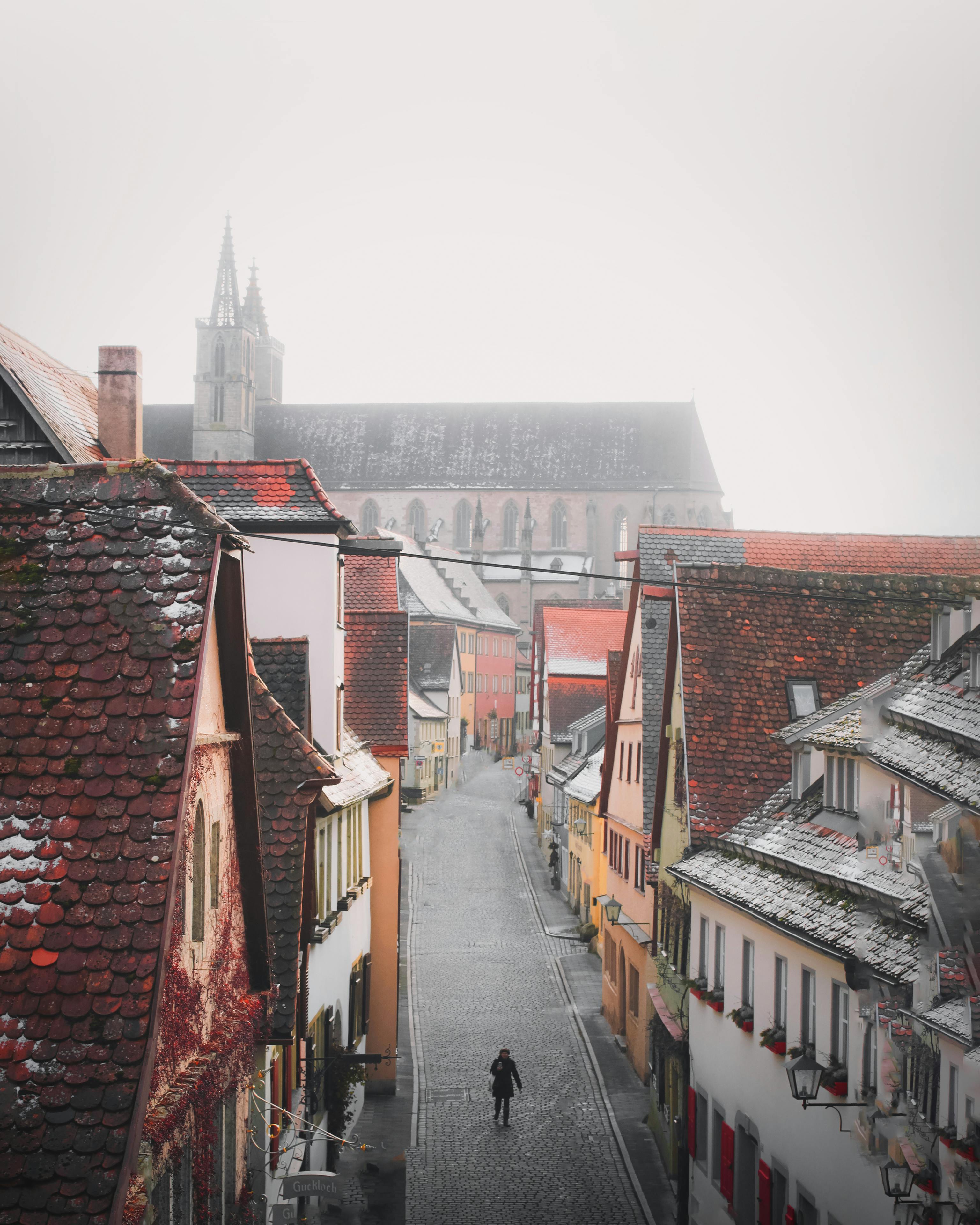 People Walking on Street Between Houses · Free Stock Photo