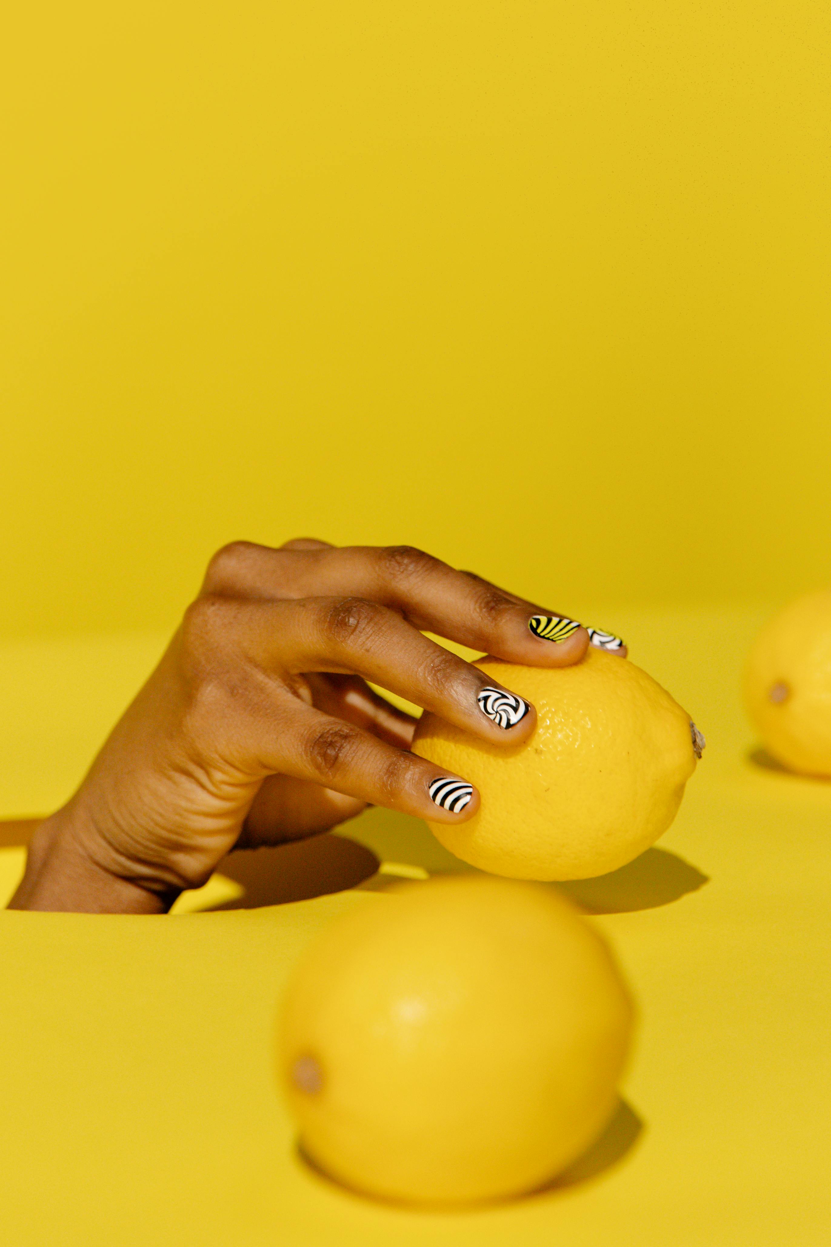 A Hand Holding a Lemon · Free Stock Photo