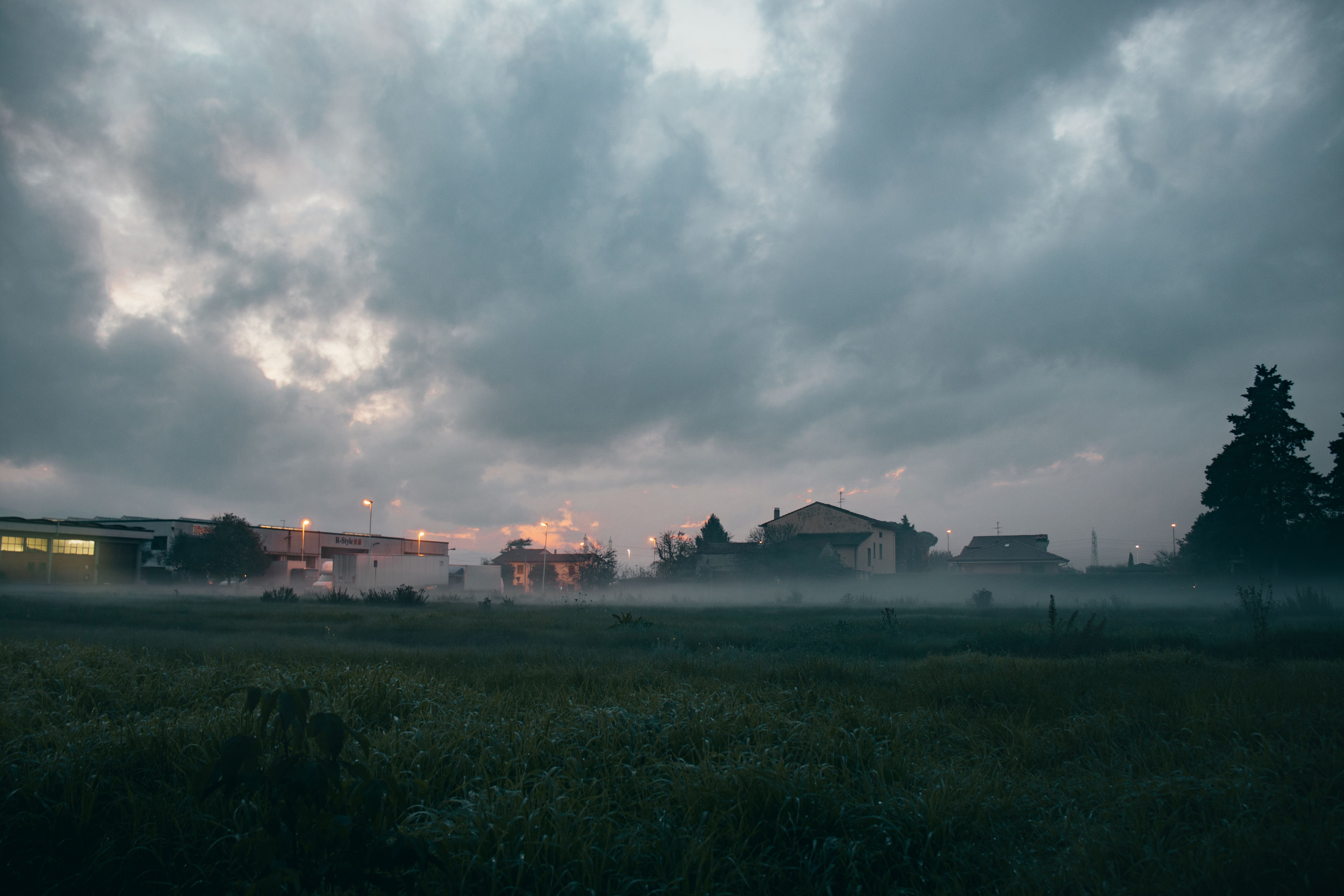 A Grass Field Under Cloudy Sky · Free Stock Photo