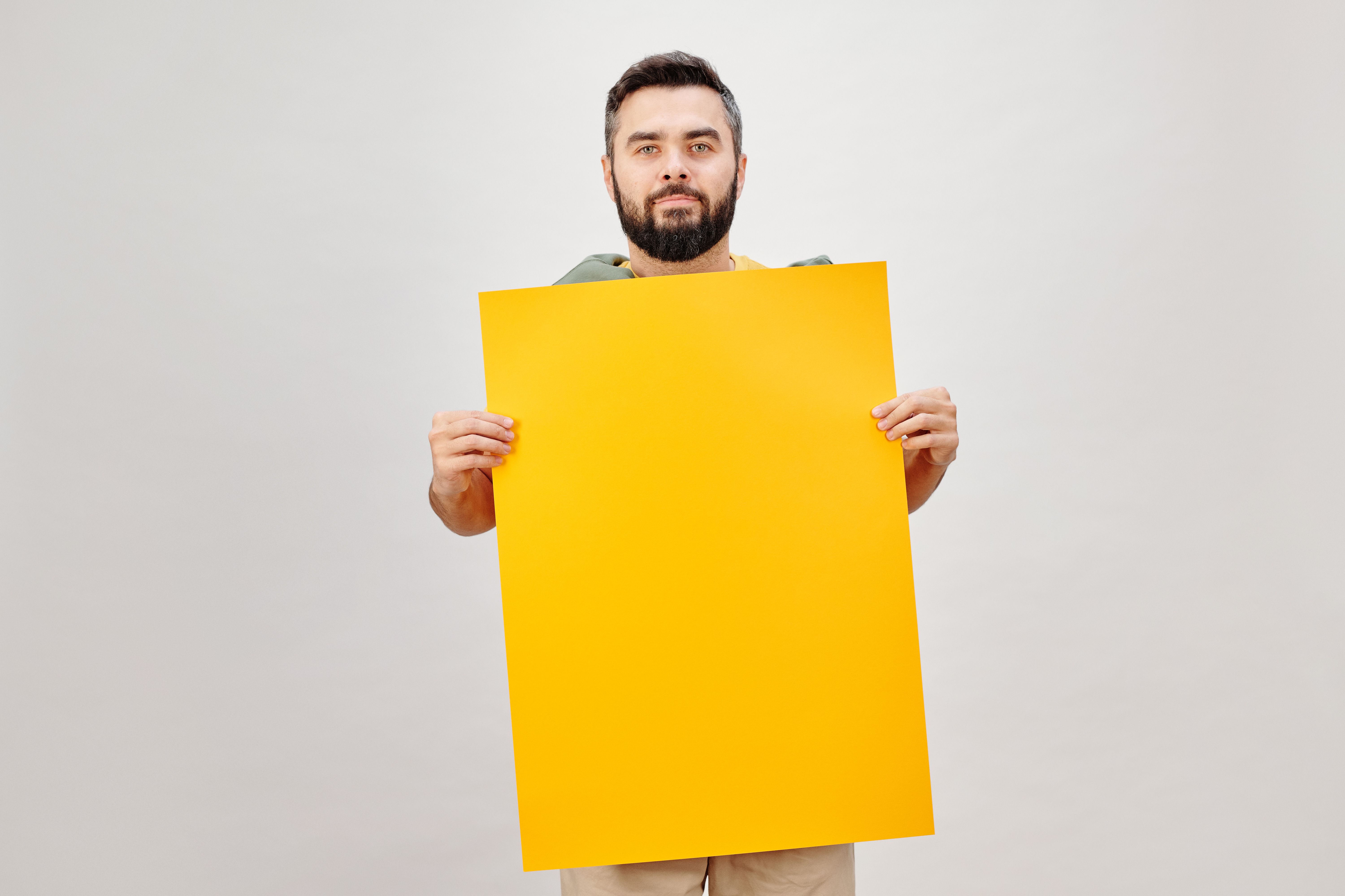 Man Holding Yellow Paper With White Background · Free Stock Photo