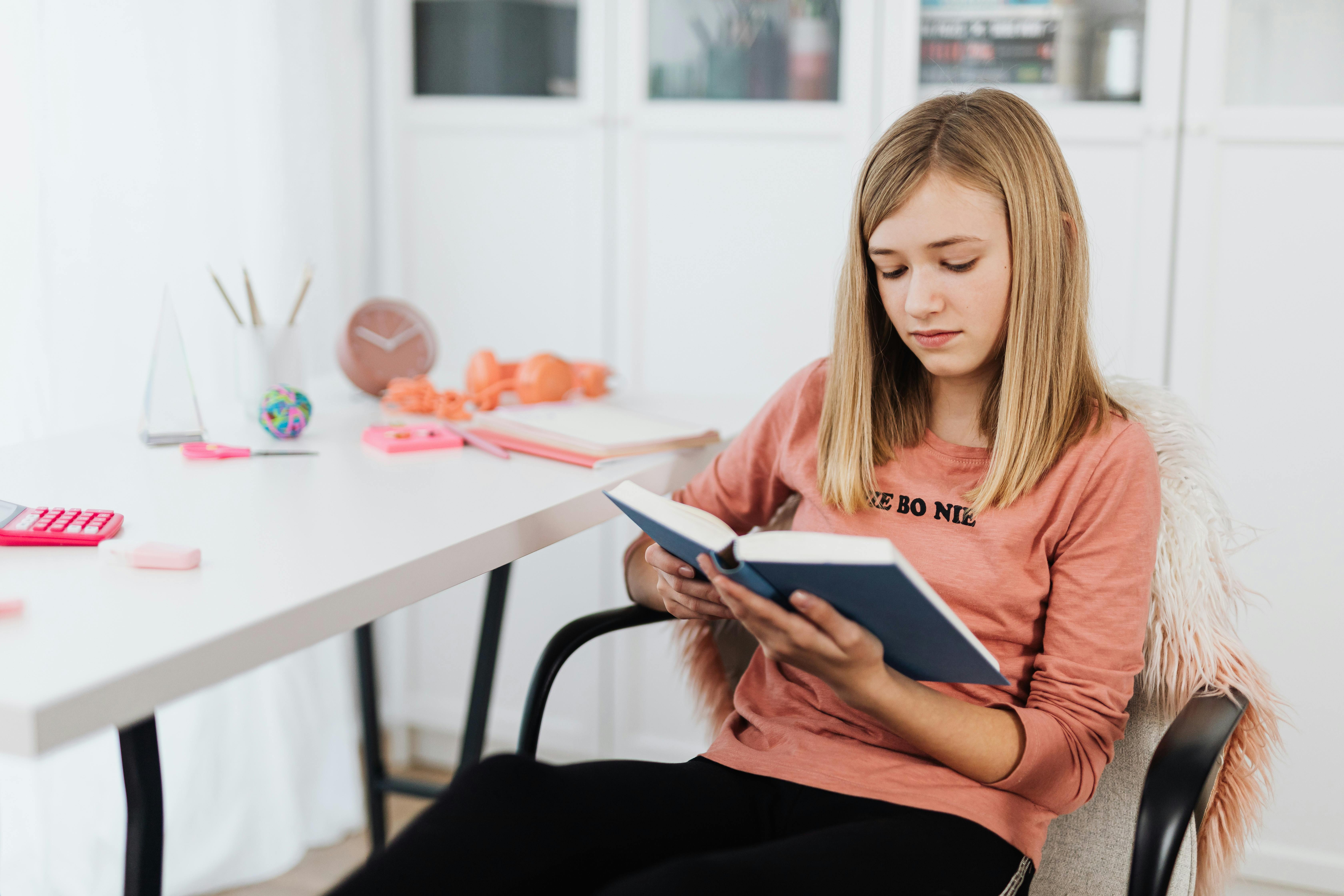 Person Sitting on Chair While Reading a Book · Free Stock Photo