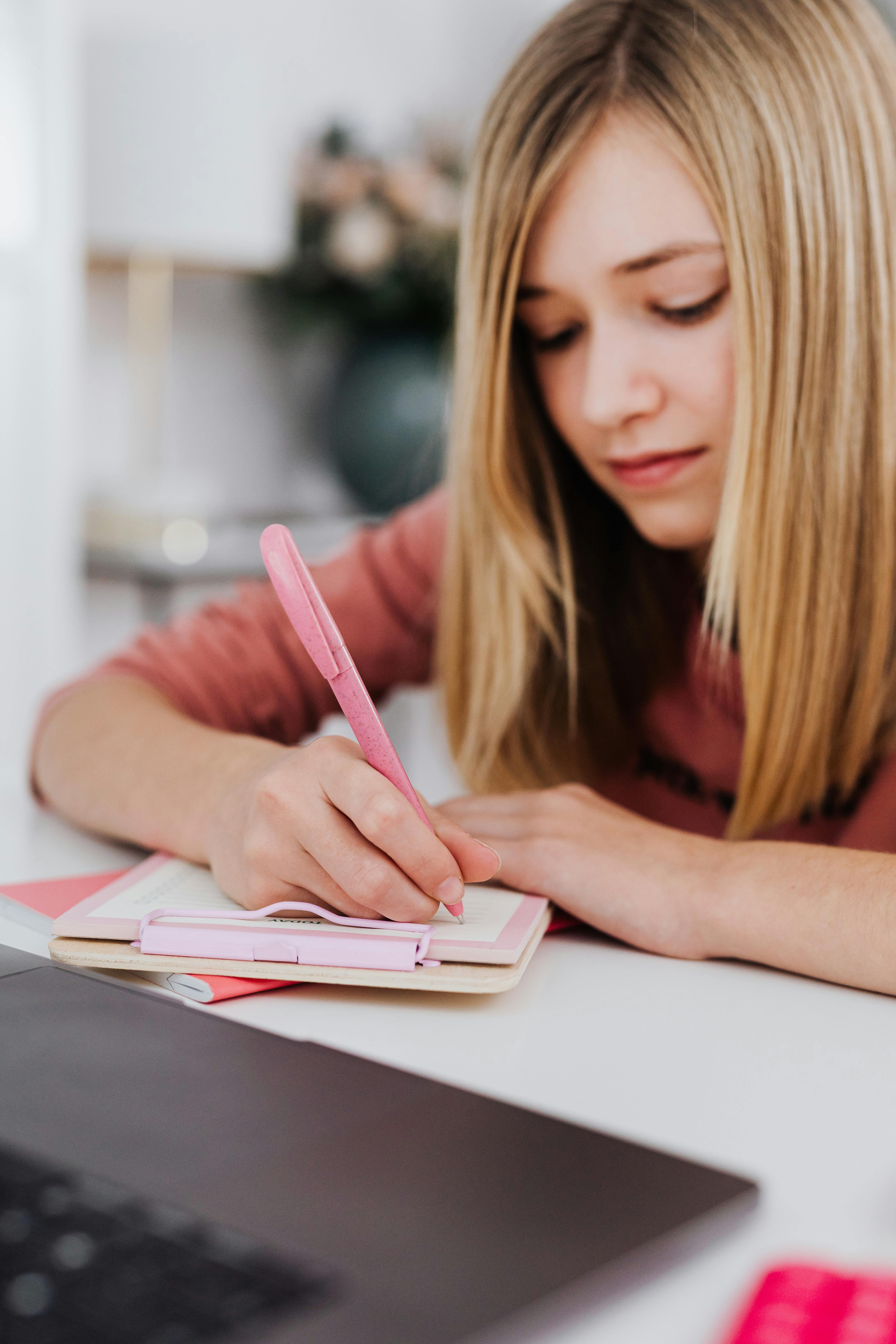 Woman Writing on a Notebook · Free Stock Photo