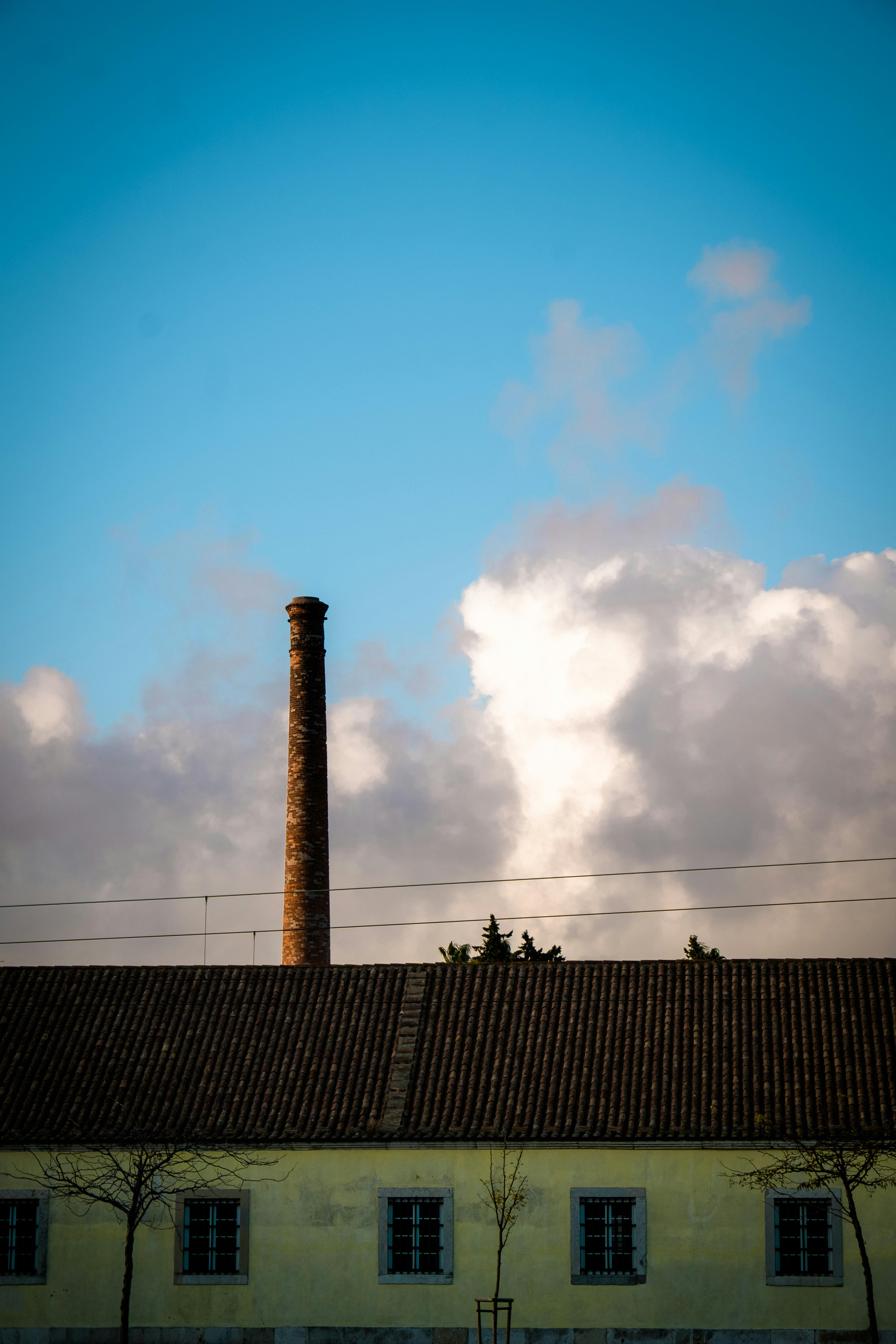 A Smokestack near a Building · Free Stock Photo