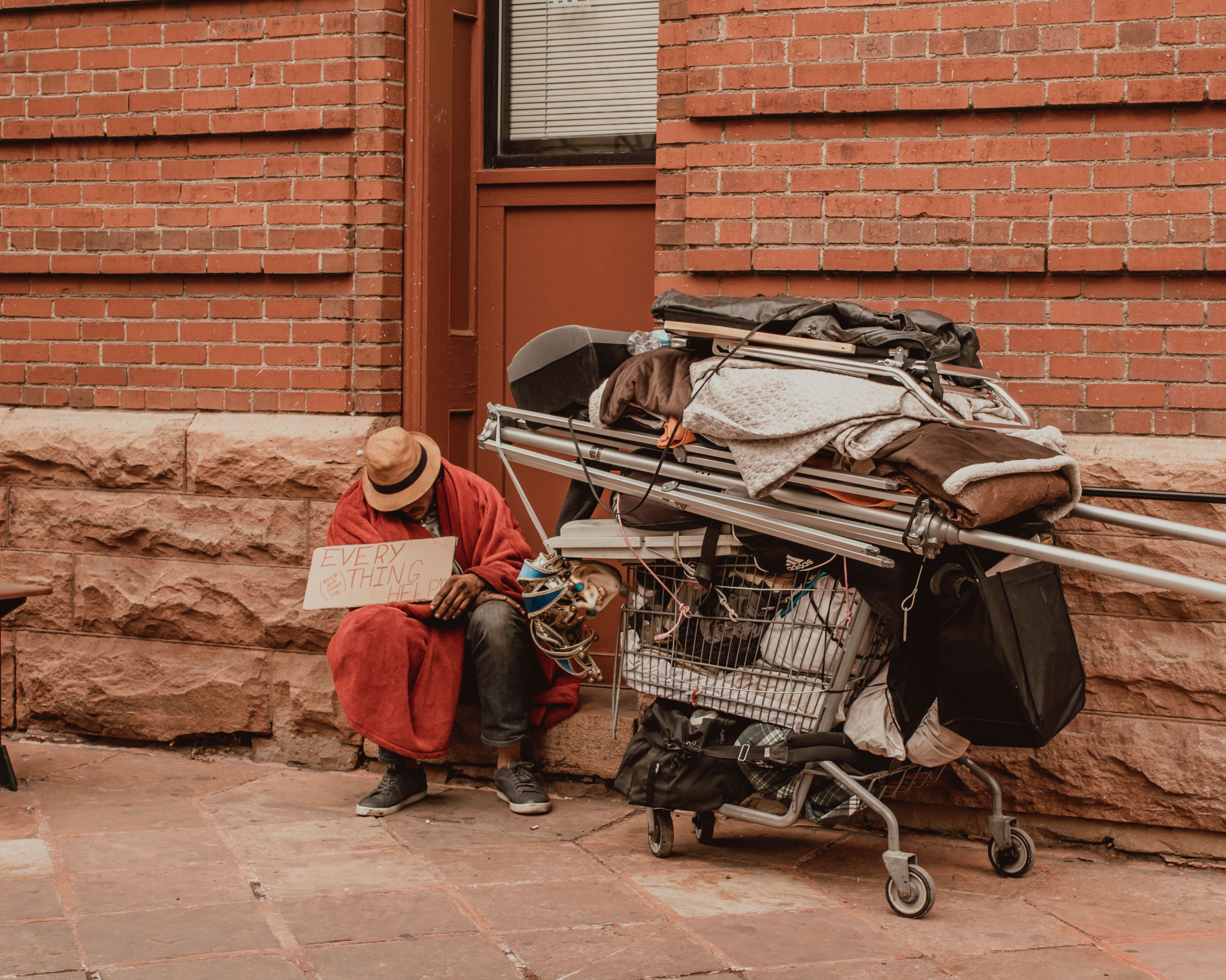 A Homeless Man Sitting in front of a Door · Free Stock Photo