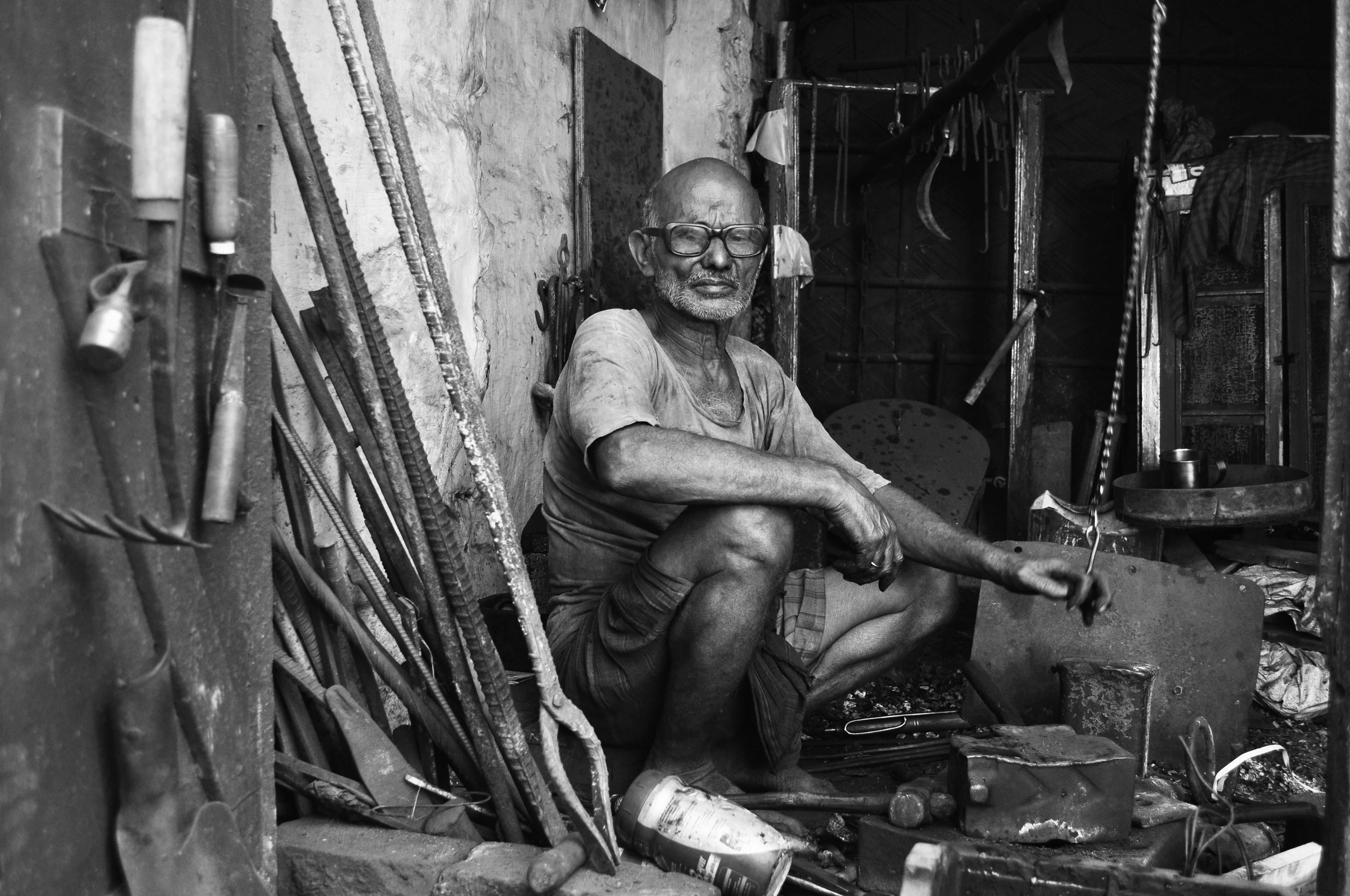 Man Sitting among Scrap Metal · Free Stock Photo
