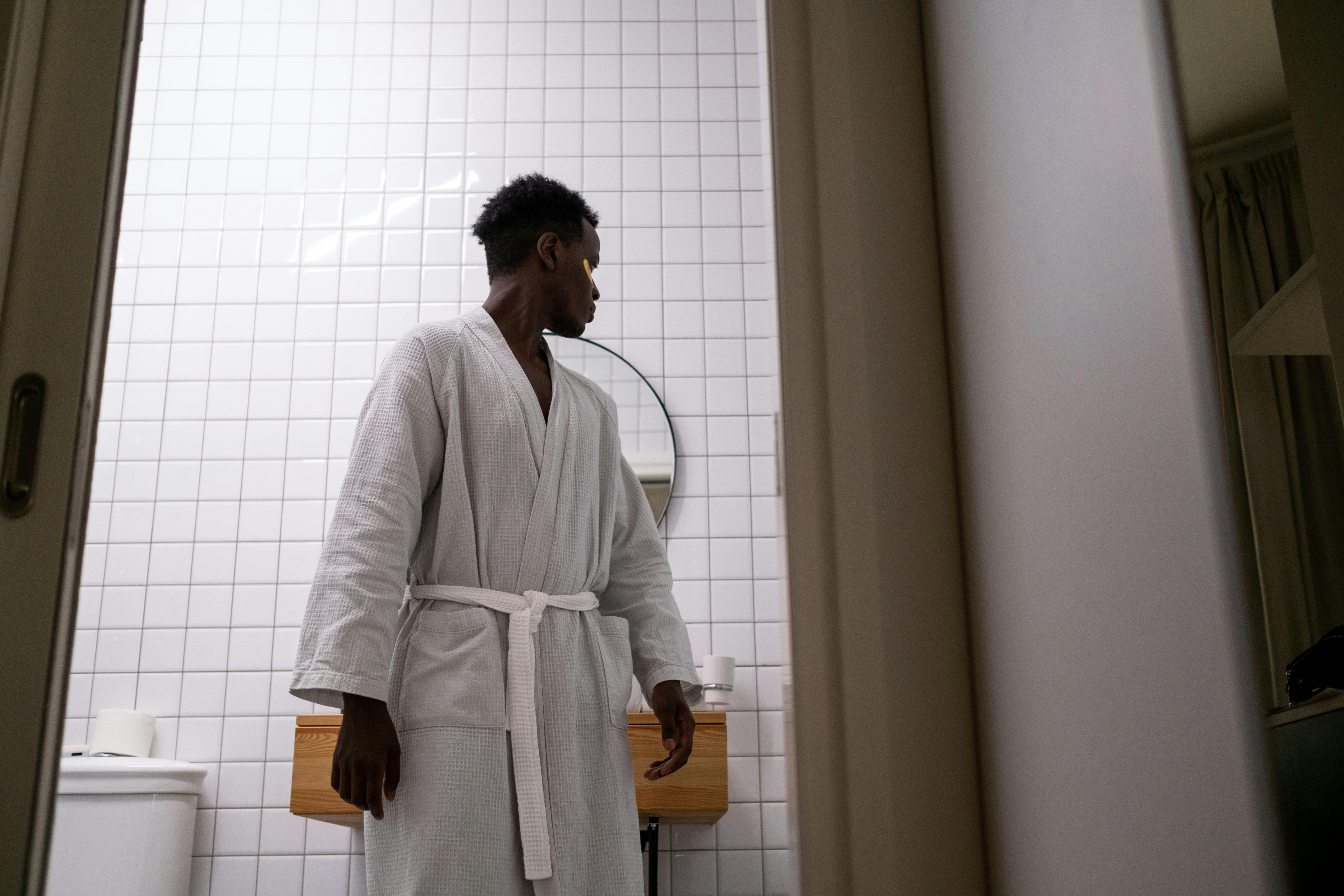 Man in White Robe Standing In Front of a Mirror · Free Stock Photo