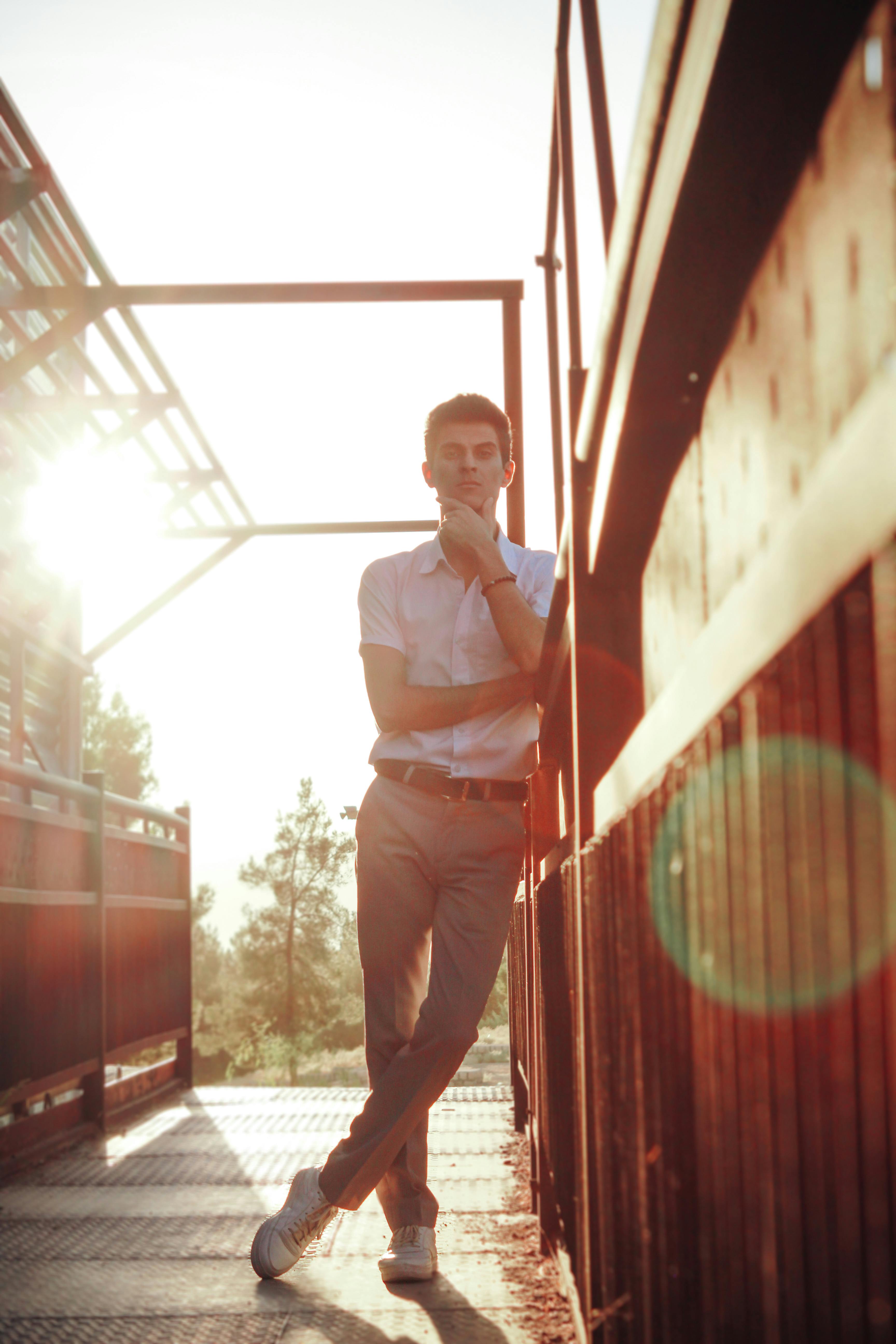 Woman in a Sundress and Sunglasses Posing by a Railing · Free Stock Photo