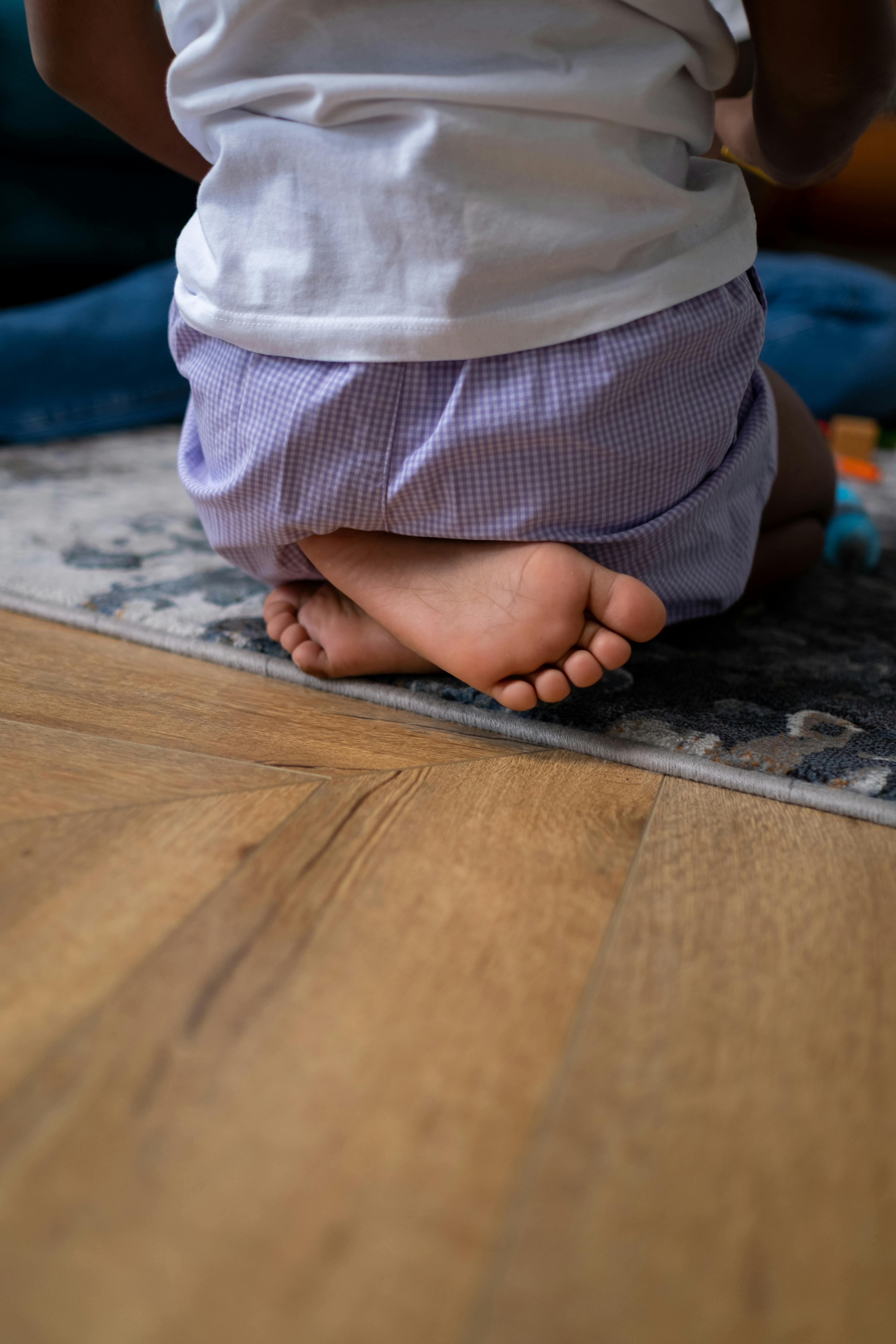 A Kid Sitting on Her Feet · Free Stock Photo