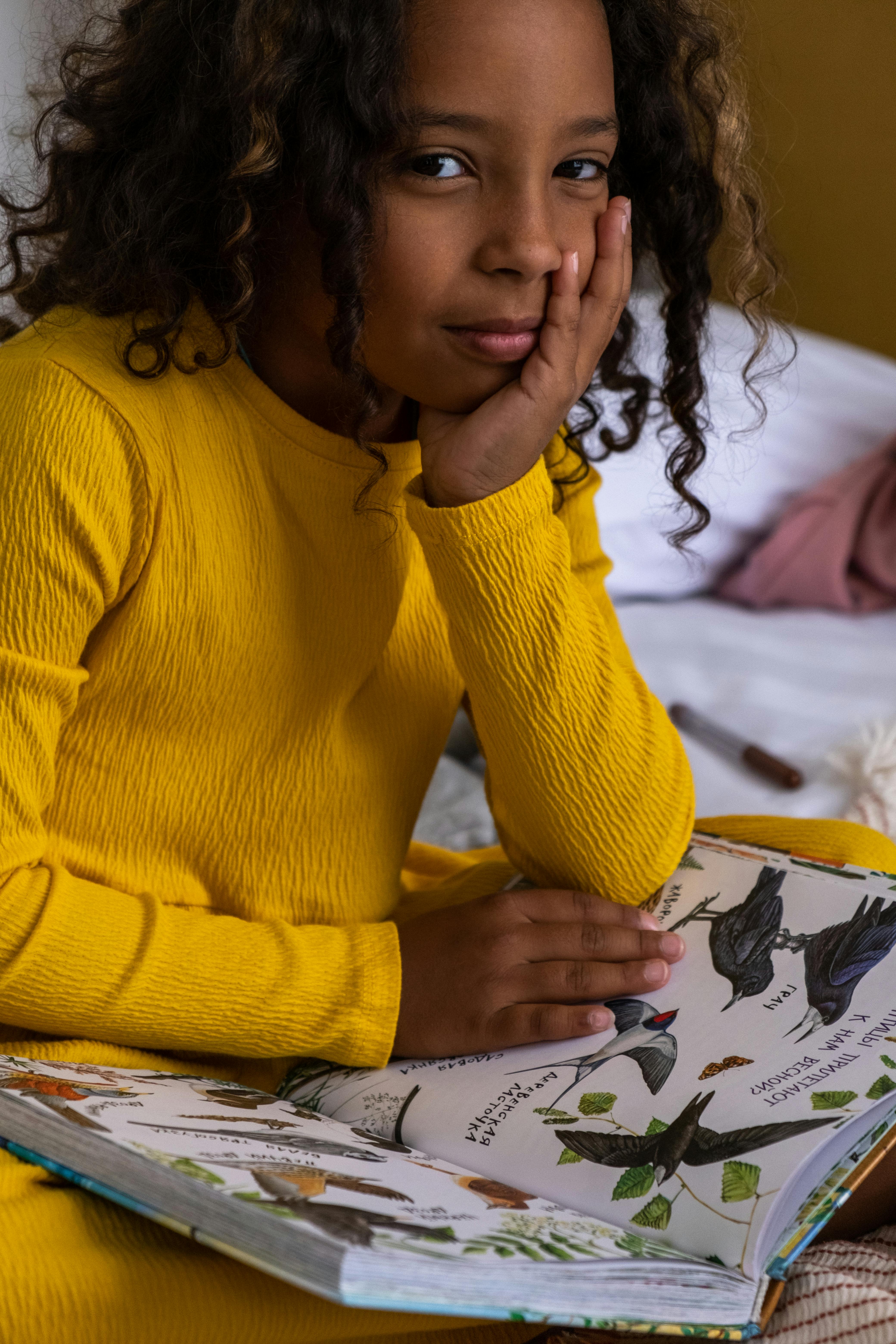 A Girl in Yellow Long Sleeve Dress Holding a Book · Free Stock Photo
