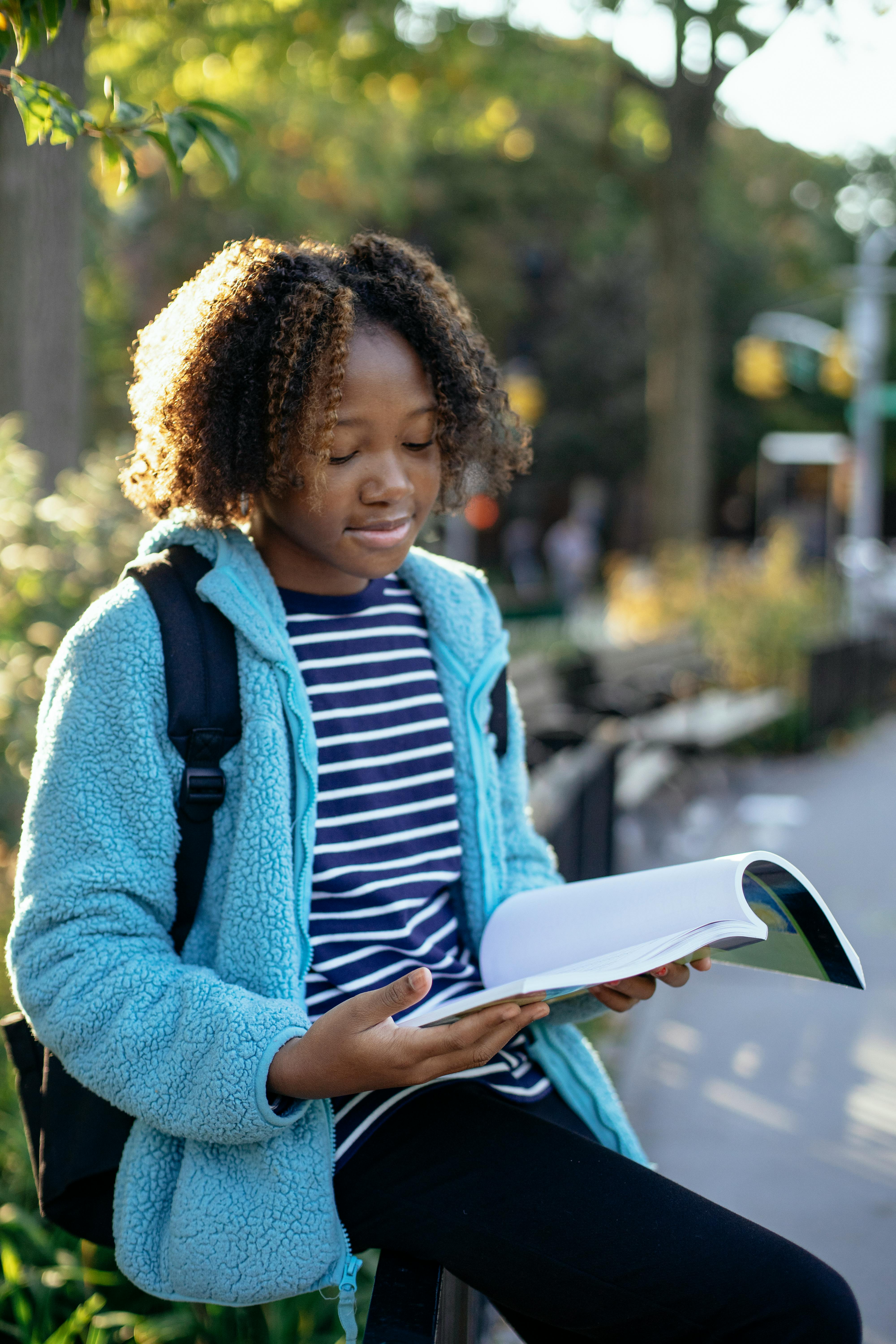 Black schoolgirl with workbook studying on street · Free Stock Photo