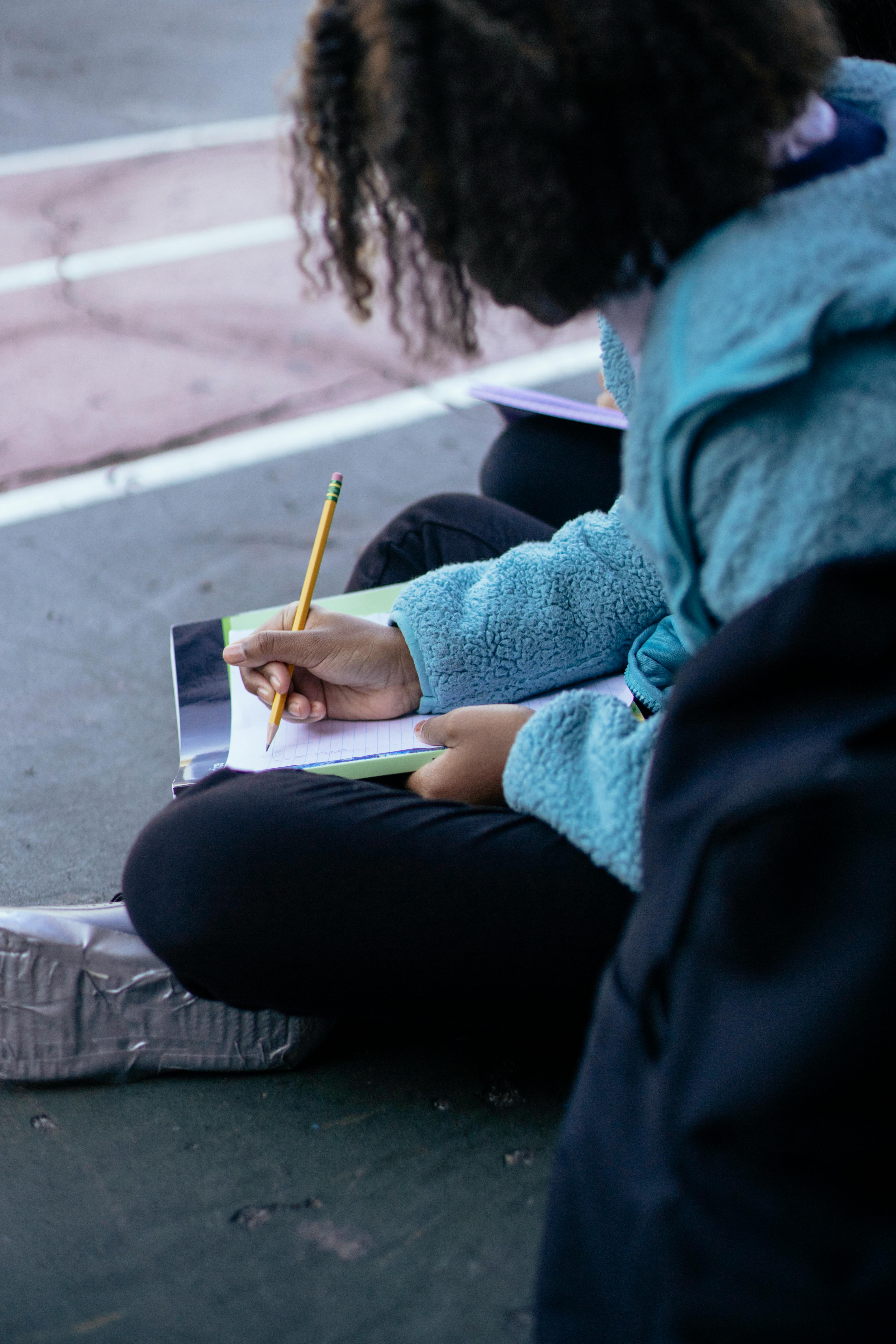 Black girl writing homework on paper · Free Stock Photo