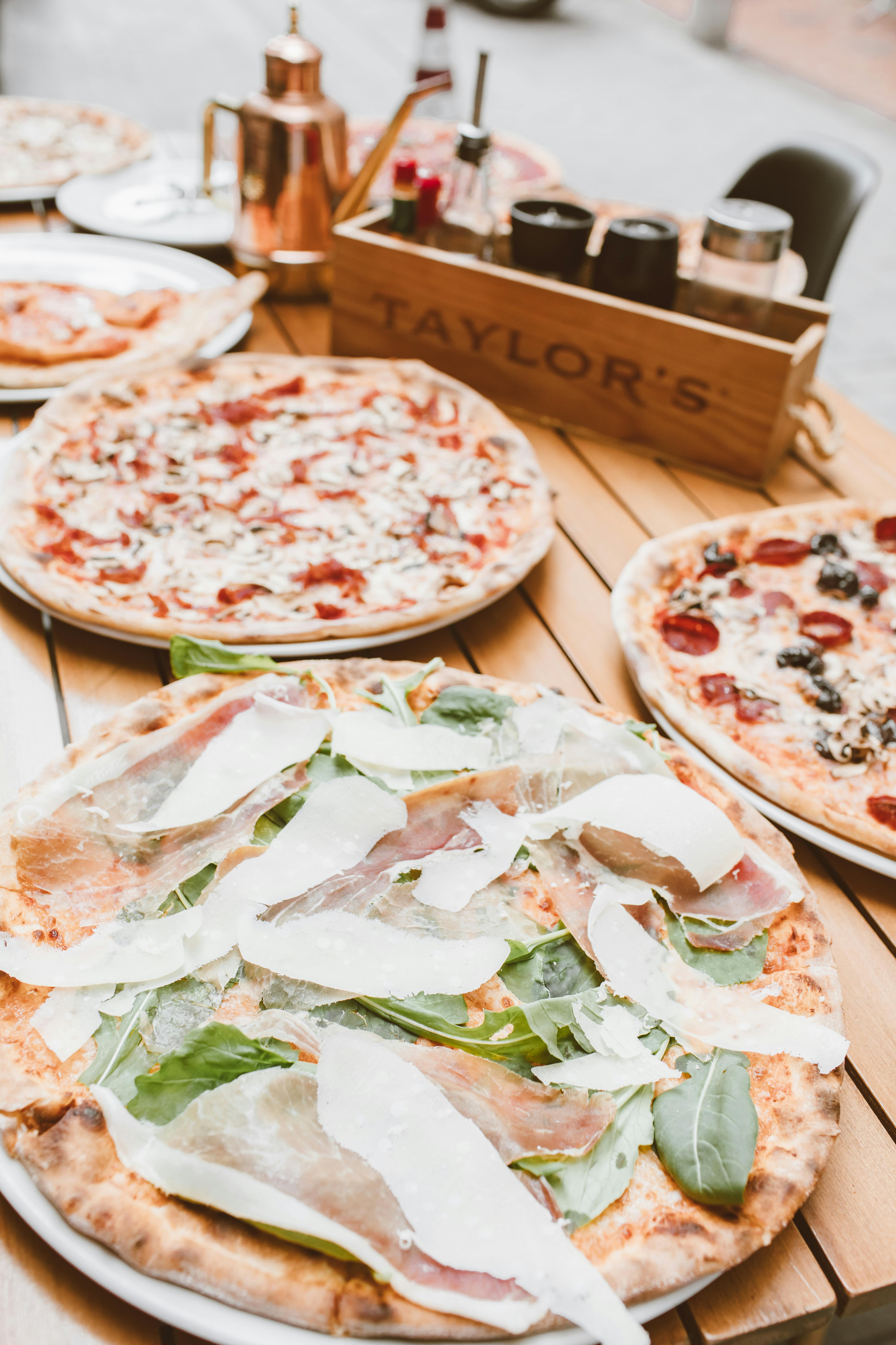 Pizzas on Wooden Table · Free Stock Photo