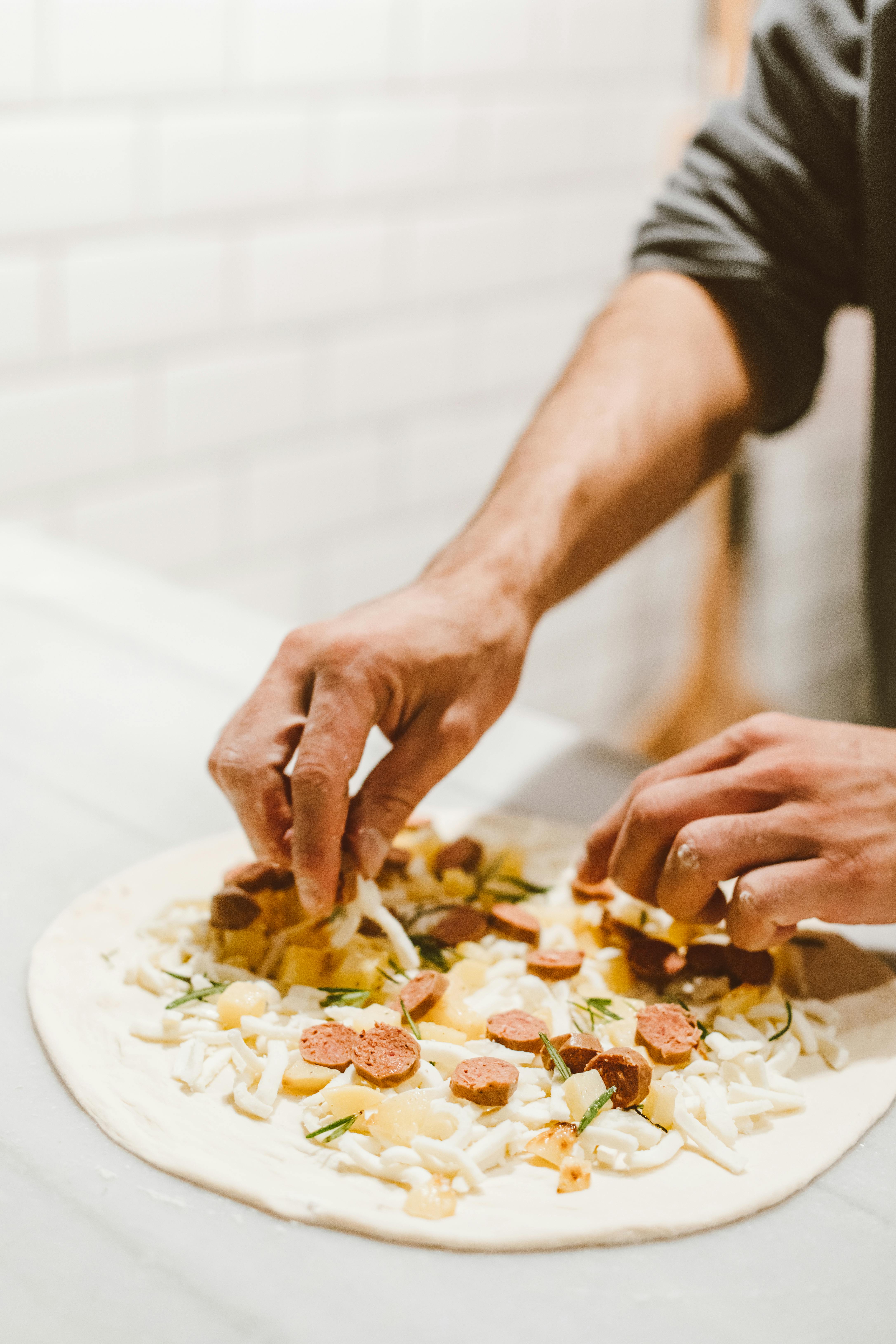 Hands Putting Toppings on a Dough · Free Stock Photo