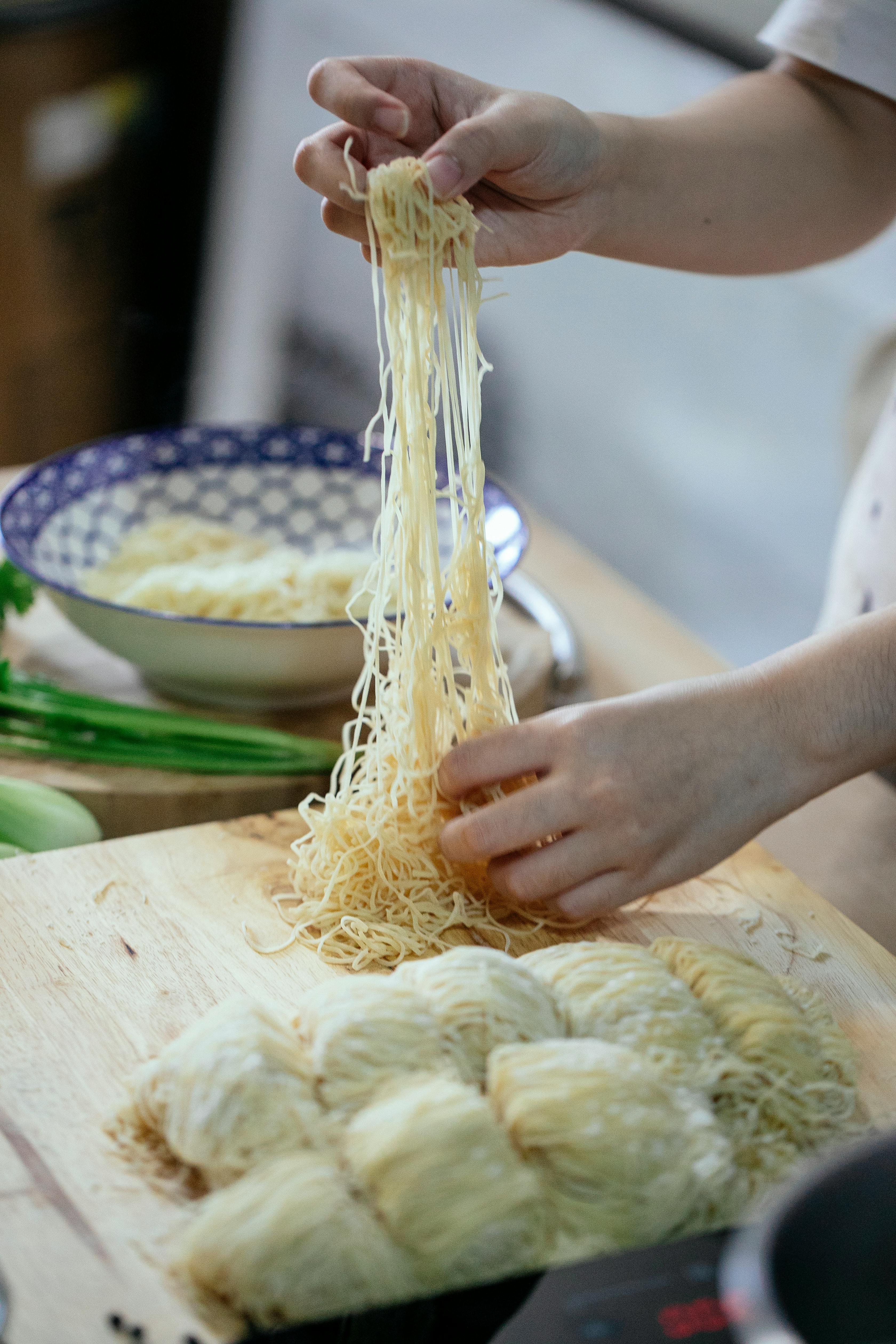 Crop person making pasta in kitchen · Free Stock Photo