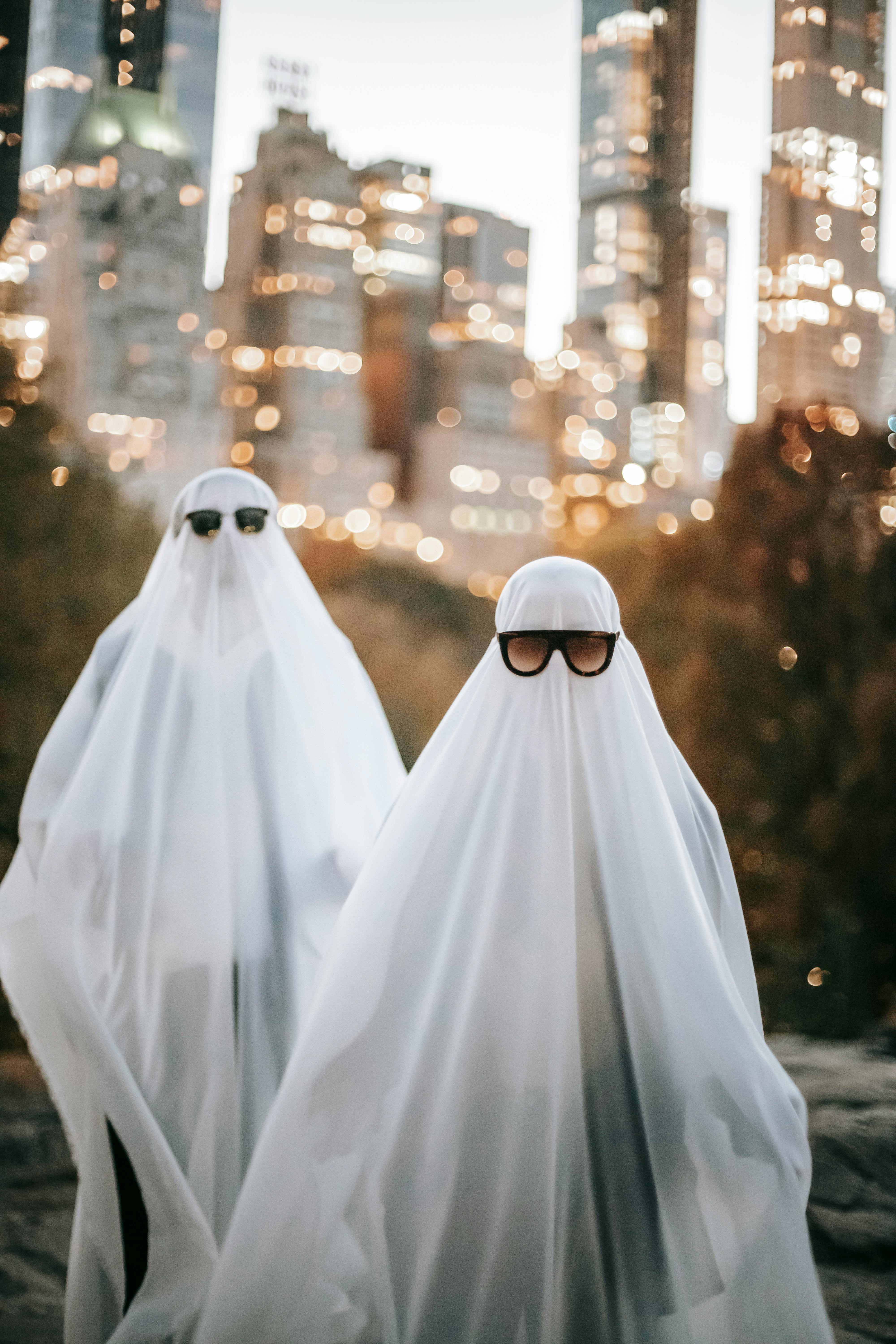 Unrecognizable couple in ghost costumes in city · Free Stock Photo