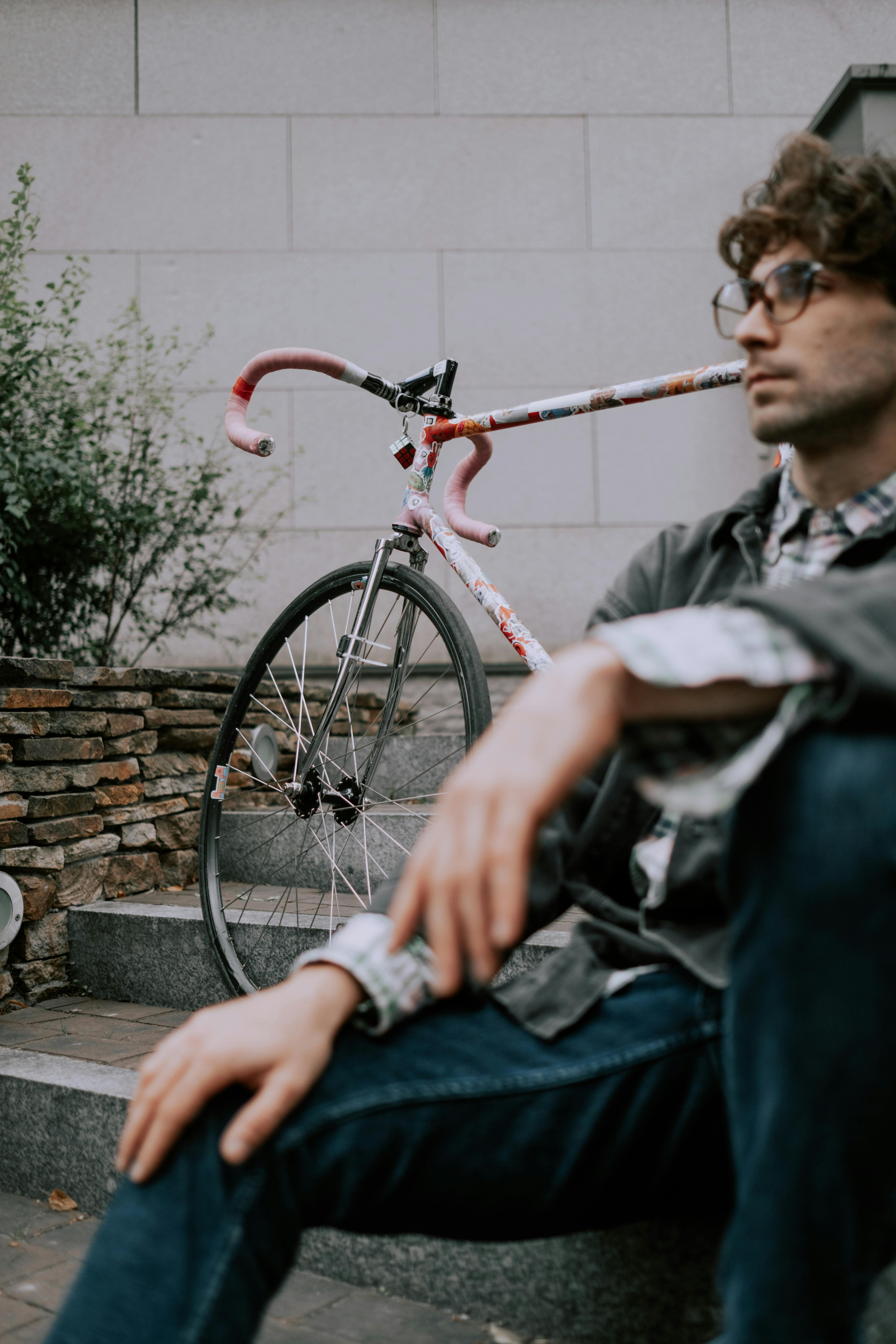 Man Sitting on the Stairs Beside a Bike · Free Stock Photo