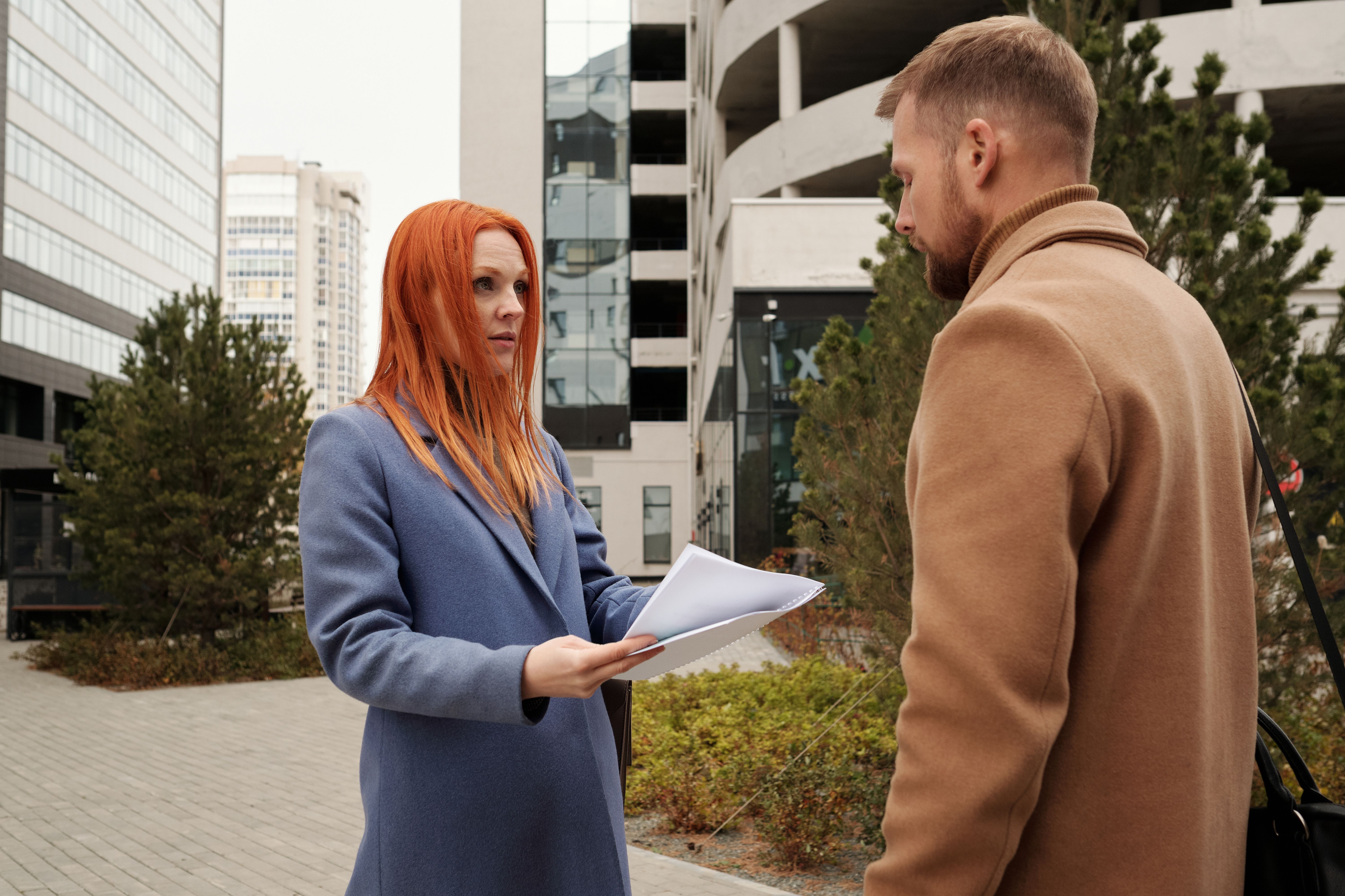 A Woman in Blue Blazer Holding White Papers · Free Stock Photo
