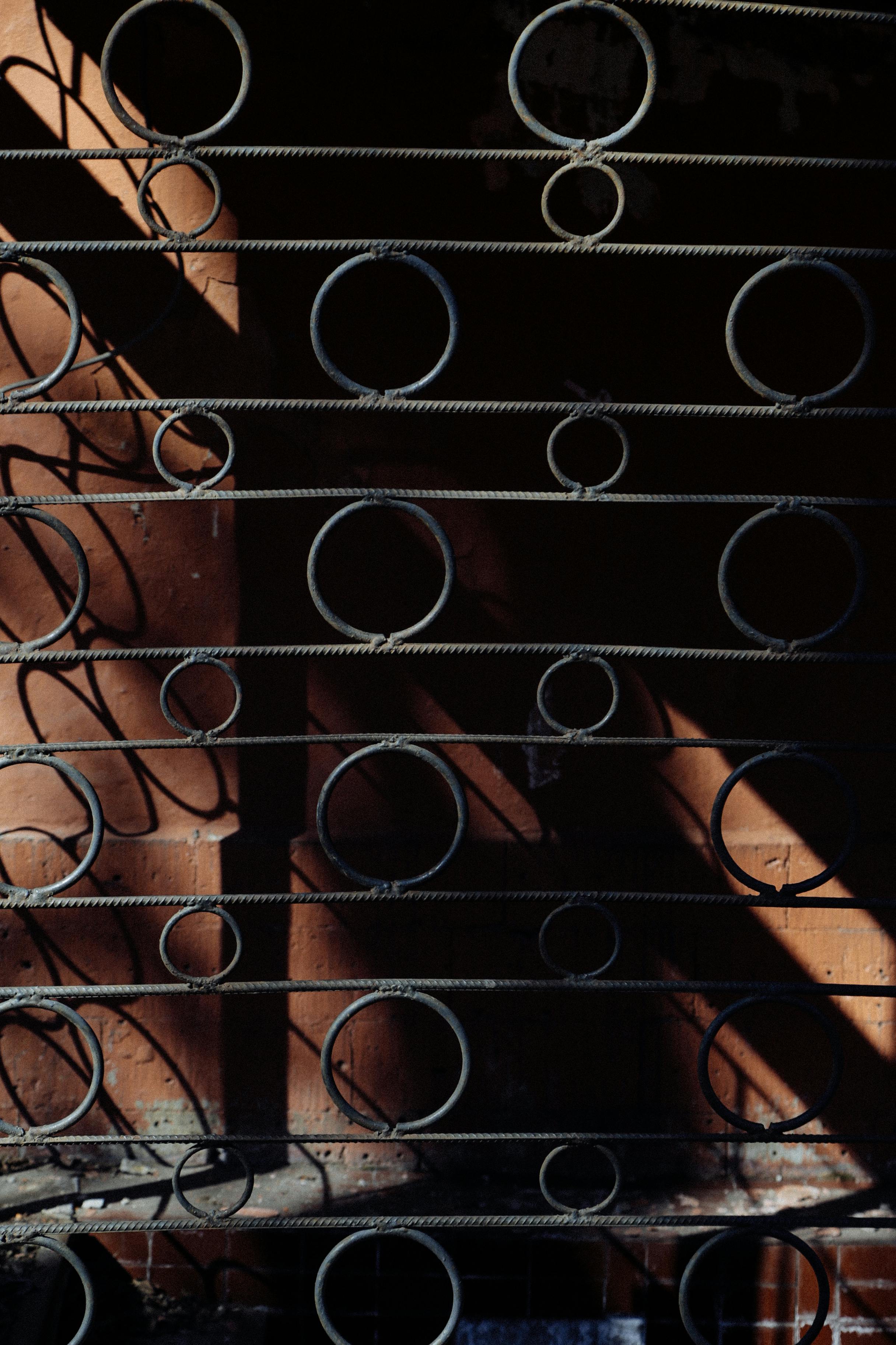 Shadow of chain link fence on pebbled ground · Free Stock Photo
