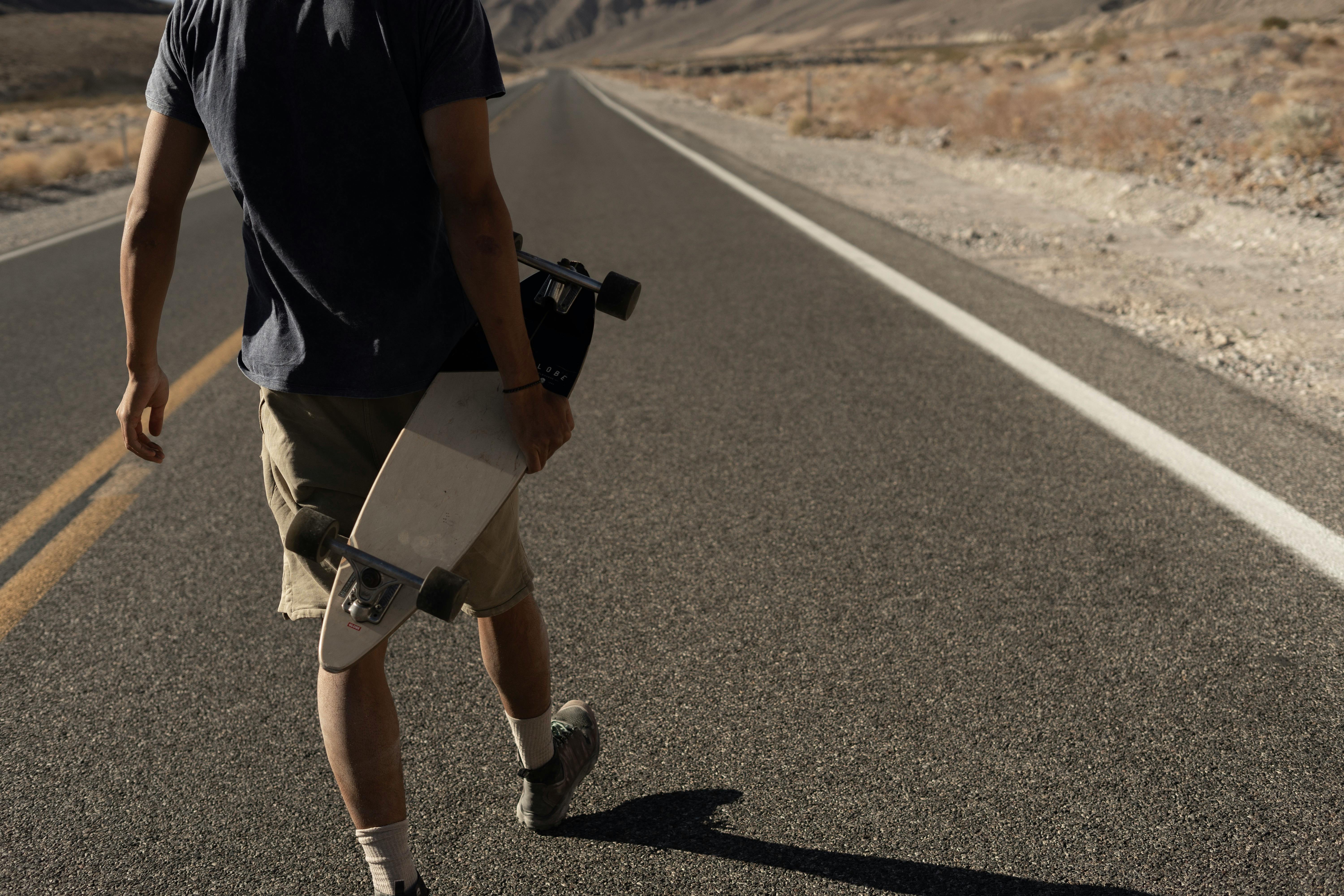 Man Carrying a Longboard · Free Stock Photo