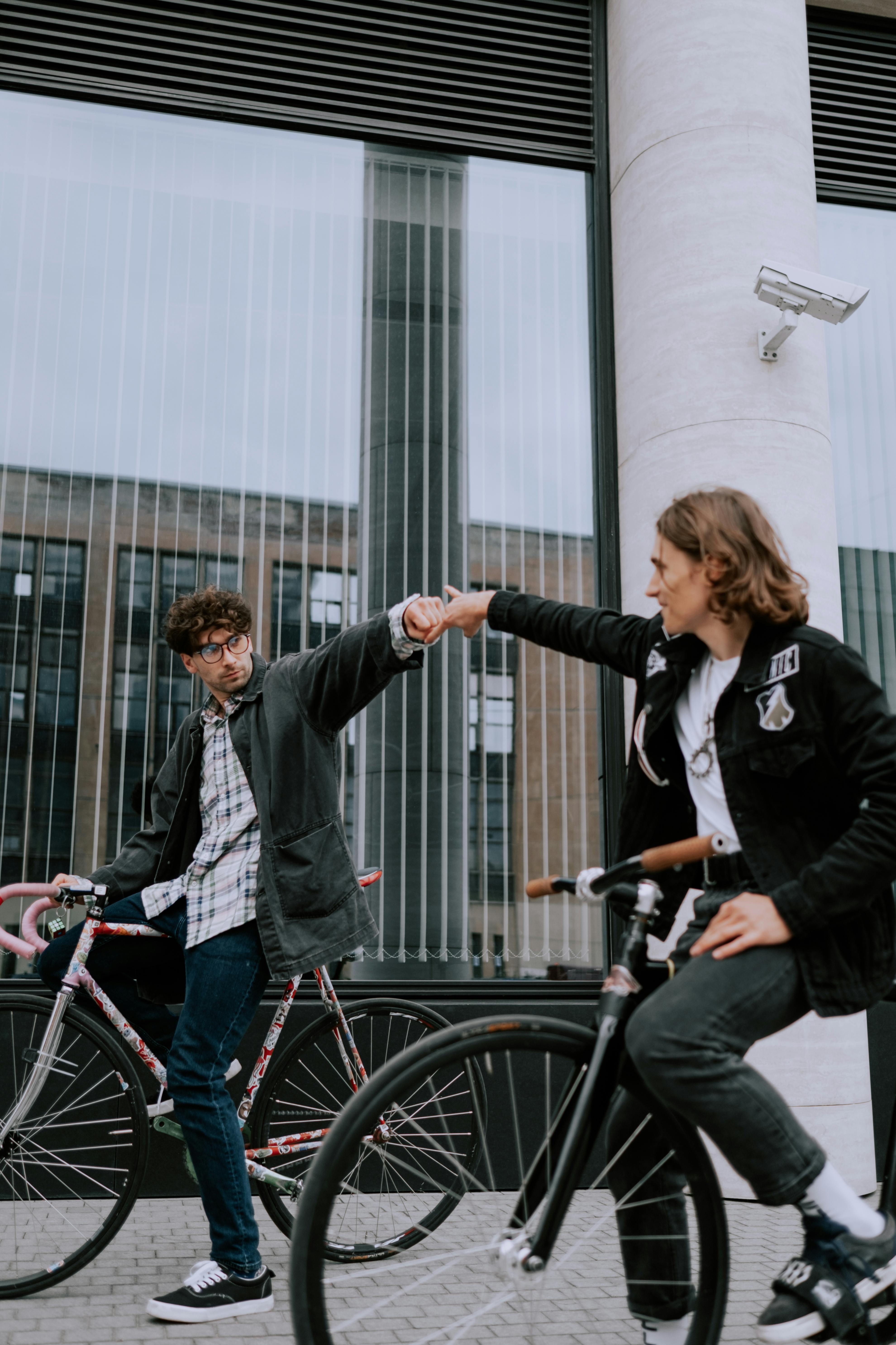 Men Sitting on Bikes Doing a Handshake · Free Stock Photo