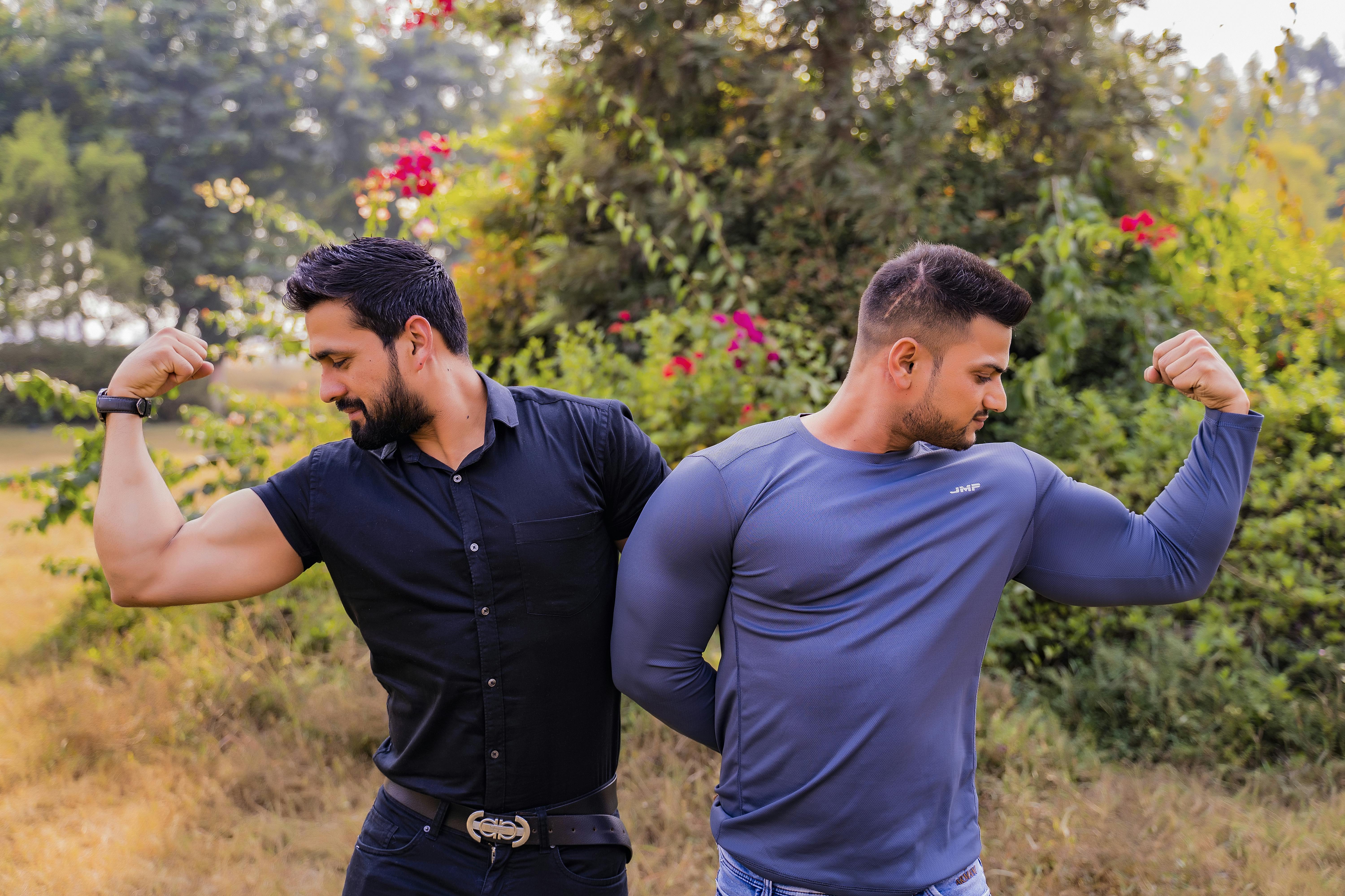 Two Muscular Men Flexing Their Biceps · Free Stock Photo