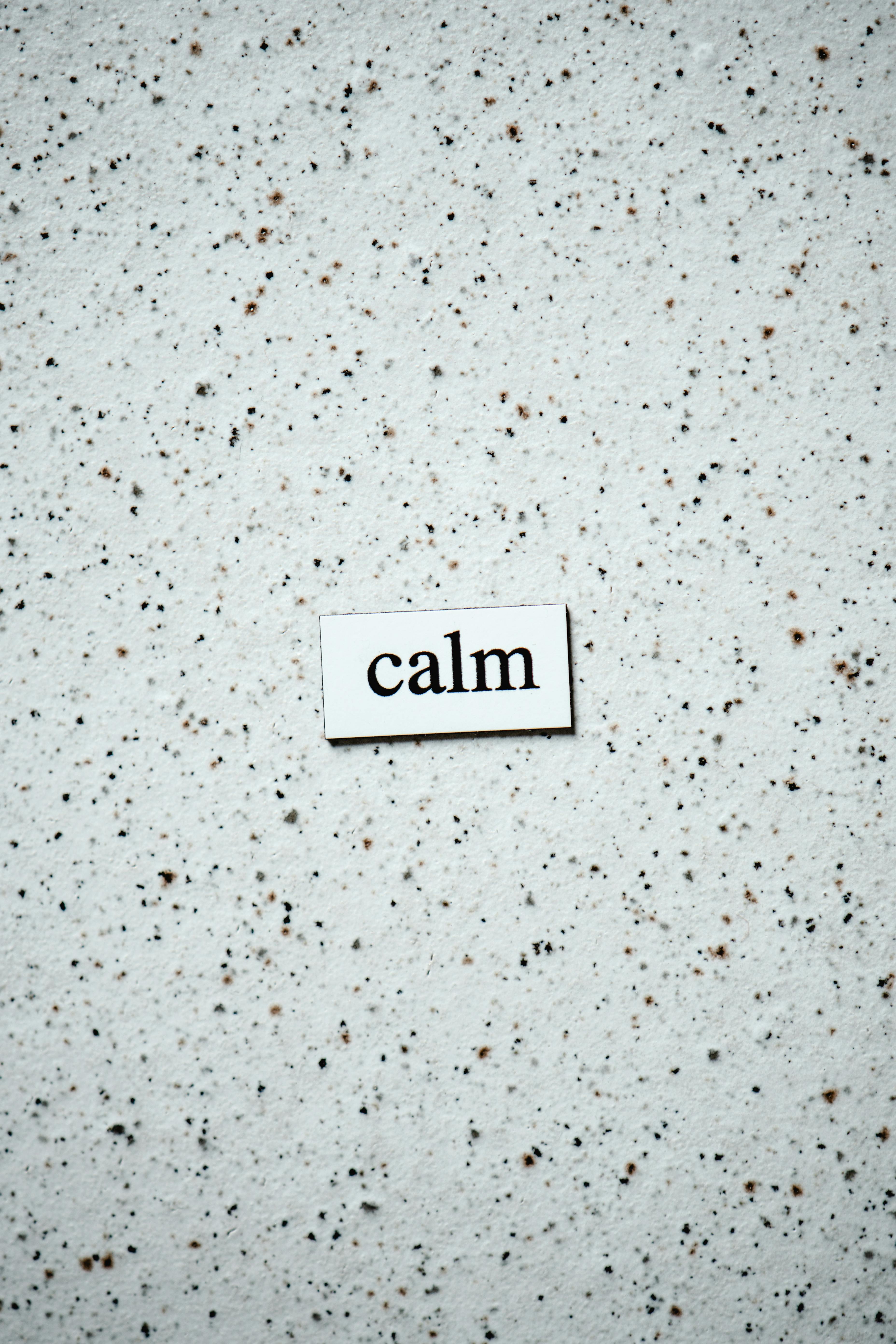 Word Saying "Calm" on a White Plaque on White Background with Black ...